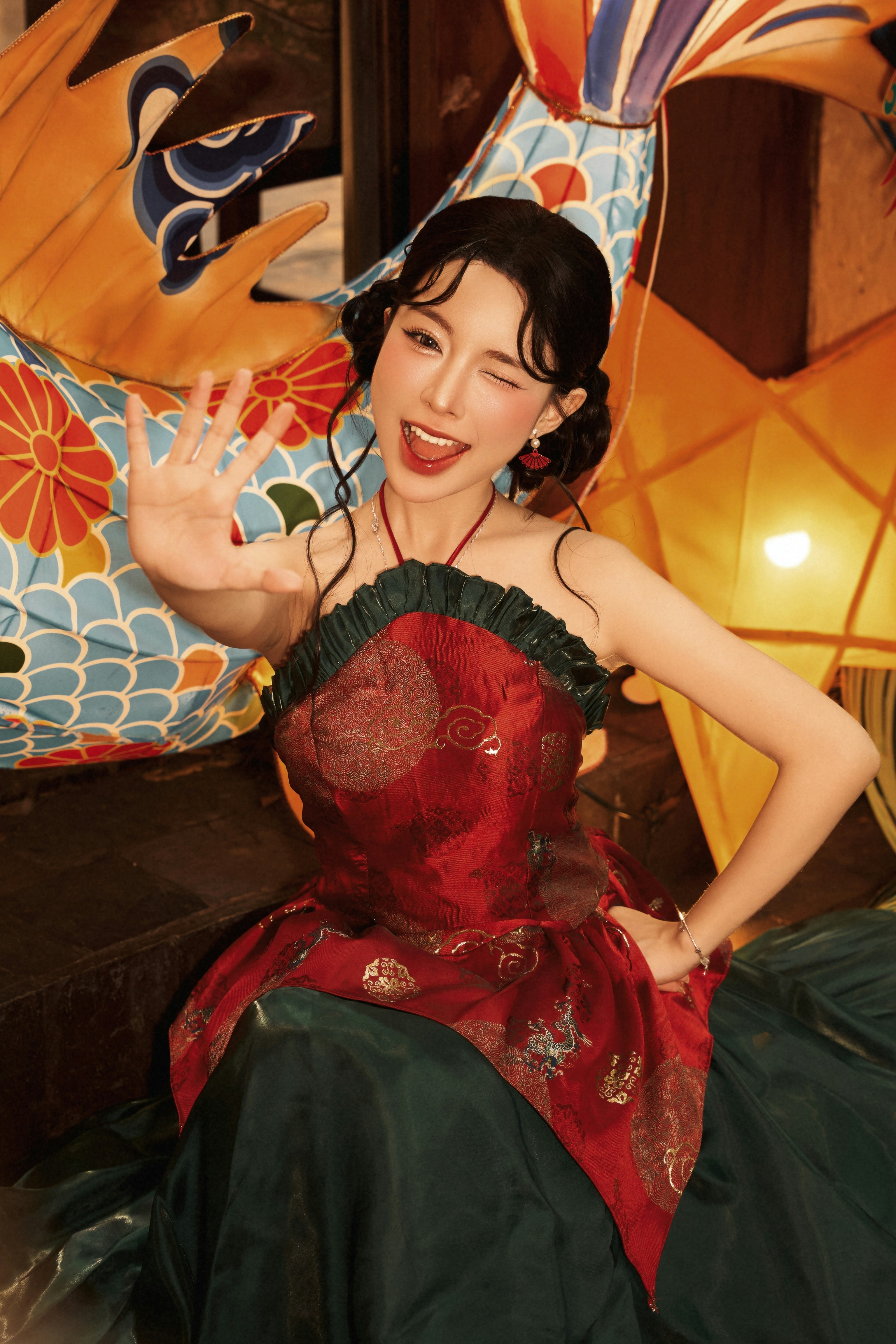 Graceful pose amid colorful dragon backdrop in festive red gown