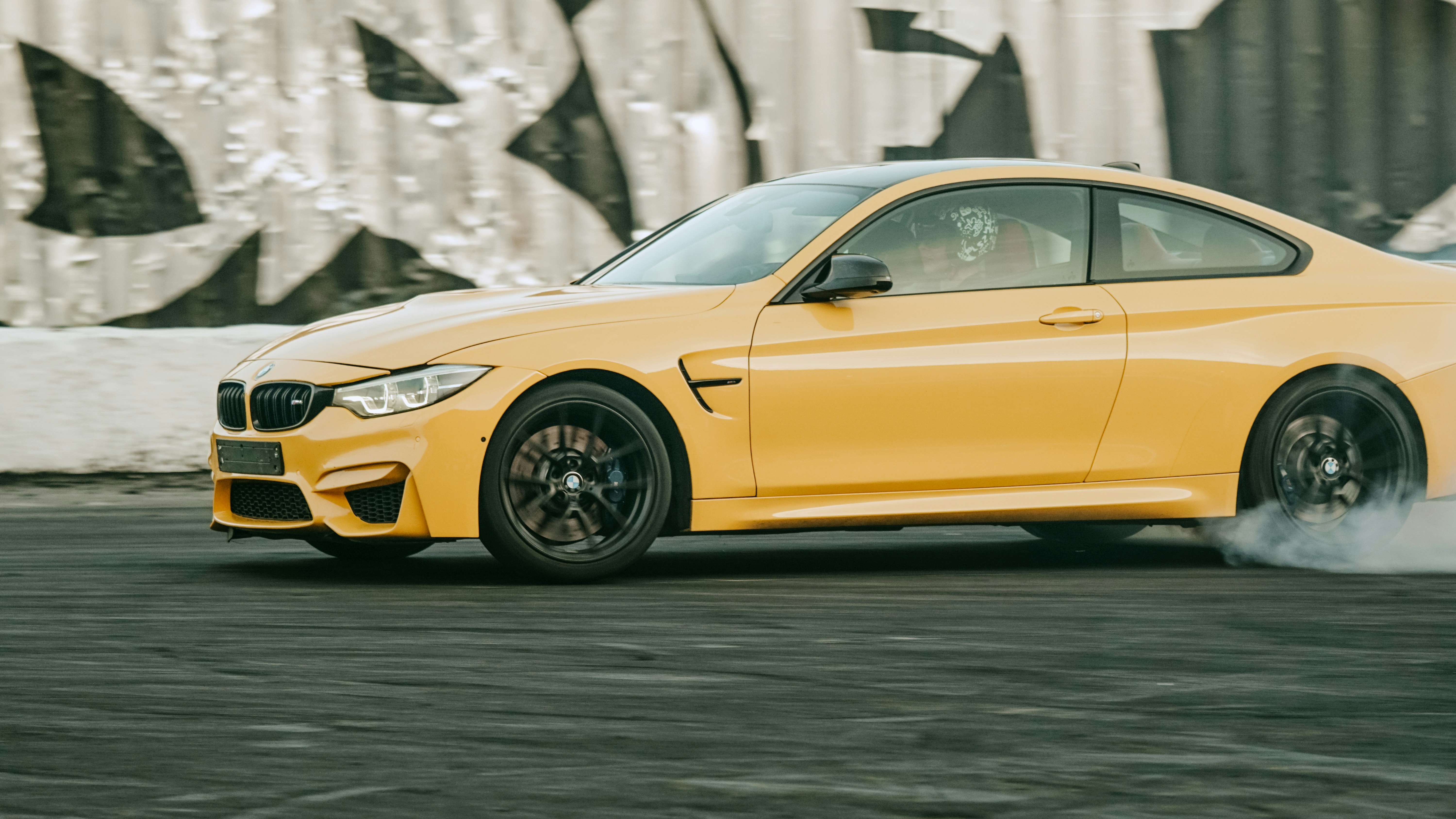 Sprint on Asphalt: A Yellow BMW Powers Through a Drift