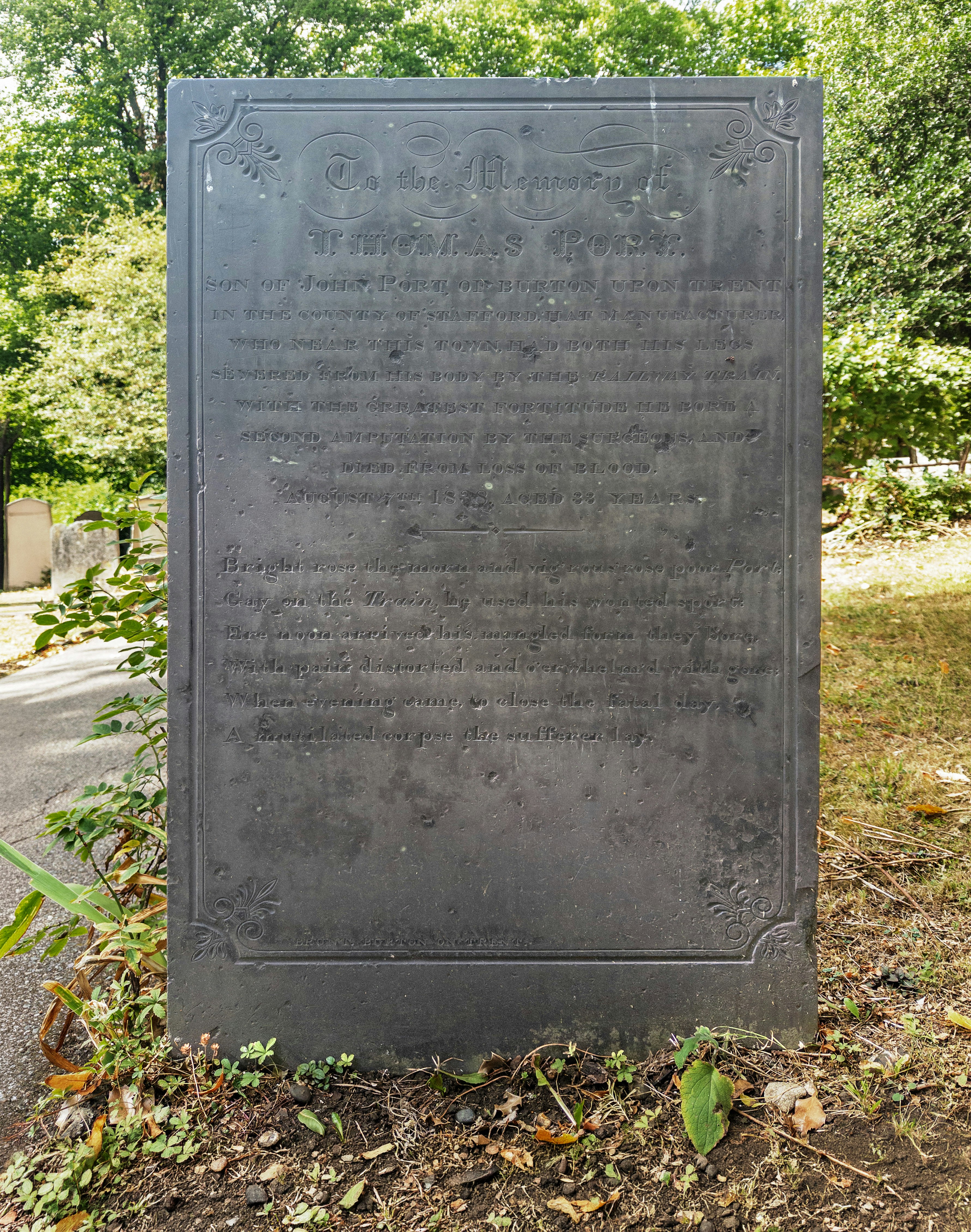 Weathered Memorial Tablet Standing Guard over a Sunlit Yard
