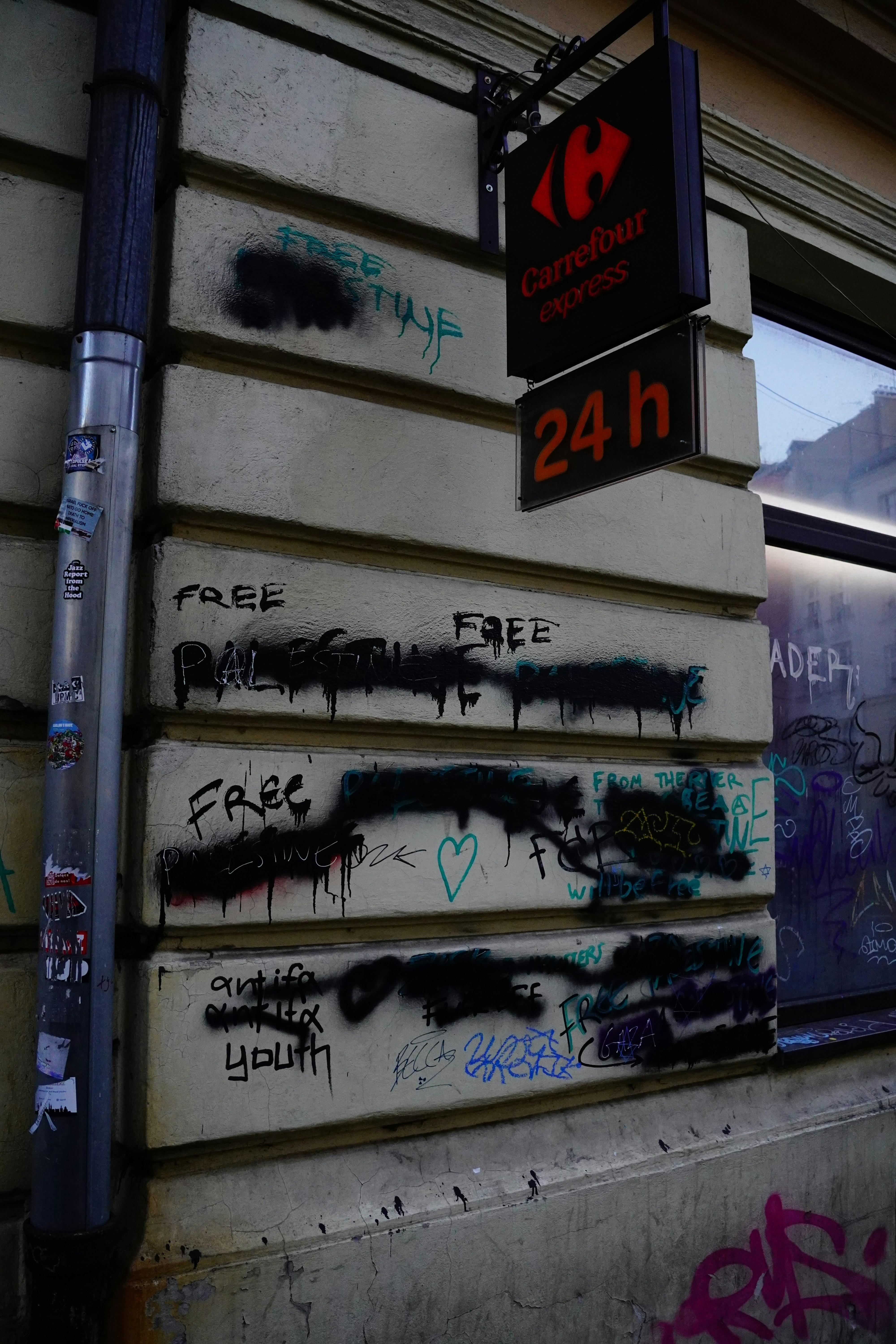 Graffiti-Clad Facade with a Corner Carrefour Sign