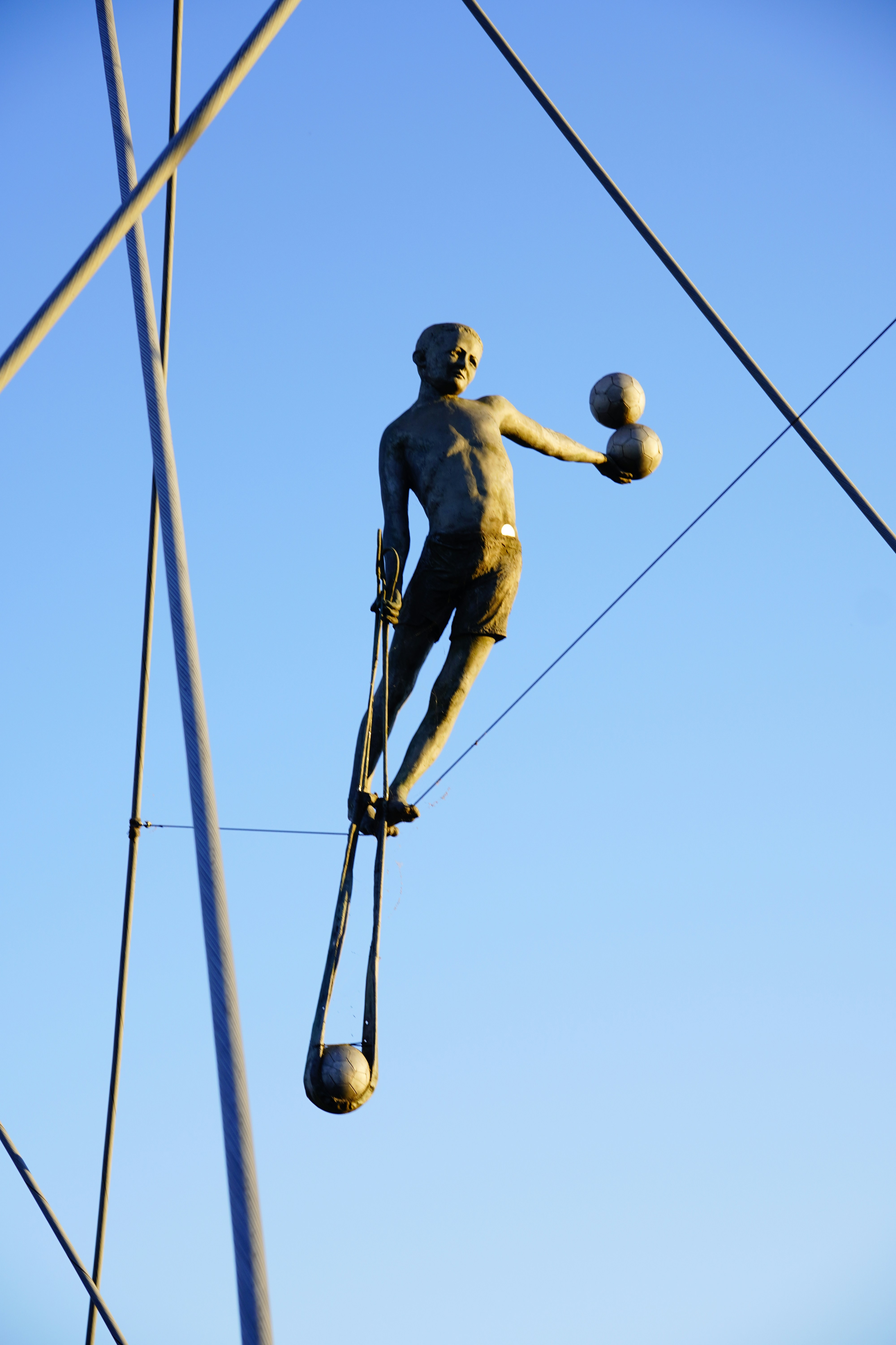 Suspended Balance: A Metal Figure Reaches Toward the Sky