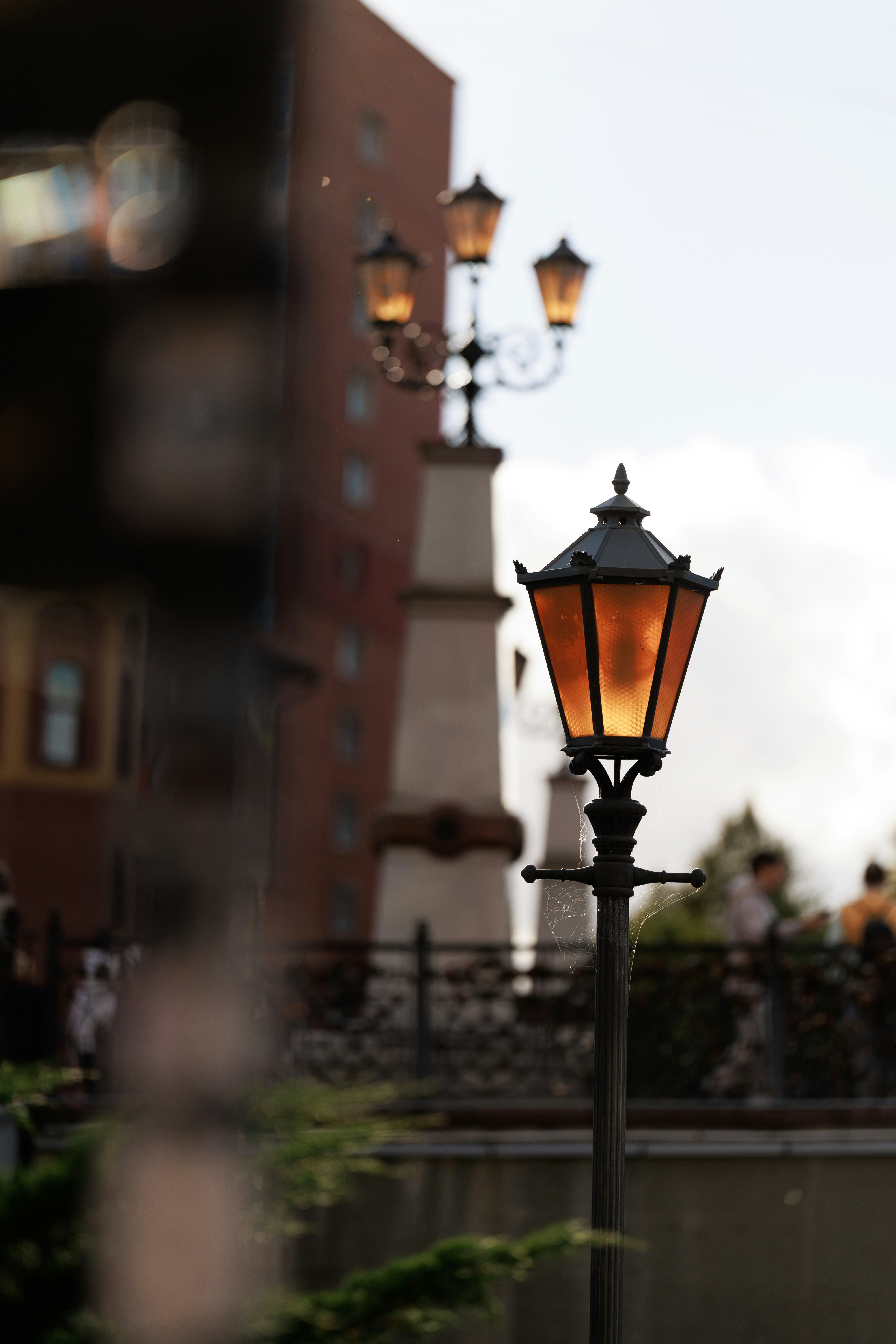 Orange Lantern in Focus: Streetlamp Portrait with Soft Urban Blur