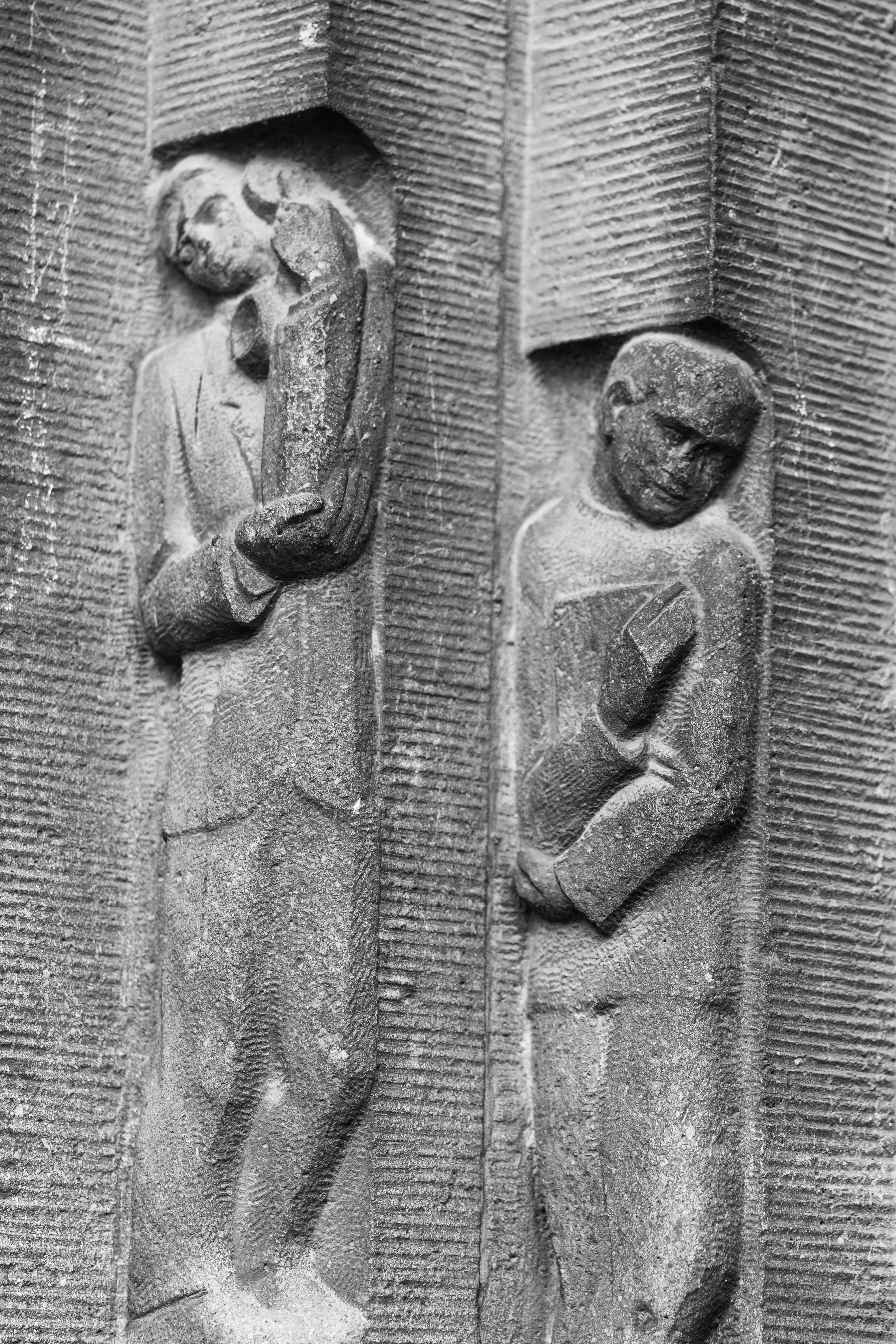 Carved Figures in Stone: Silent Vigil Beside the Pillar
