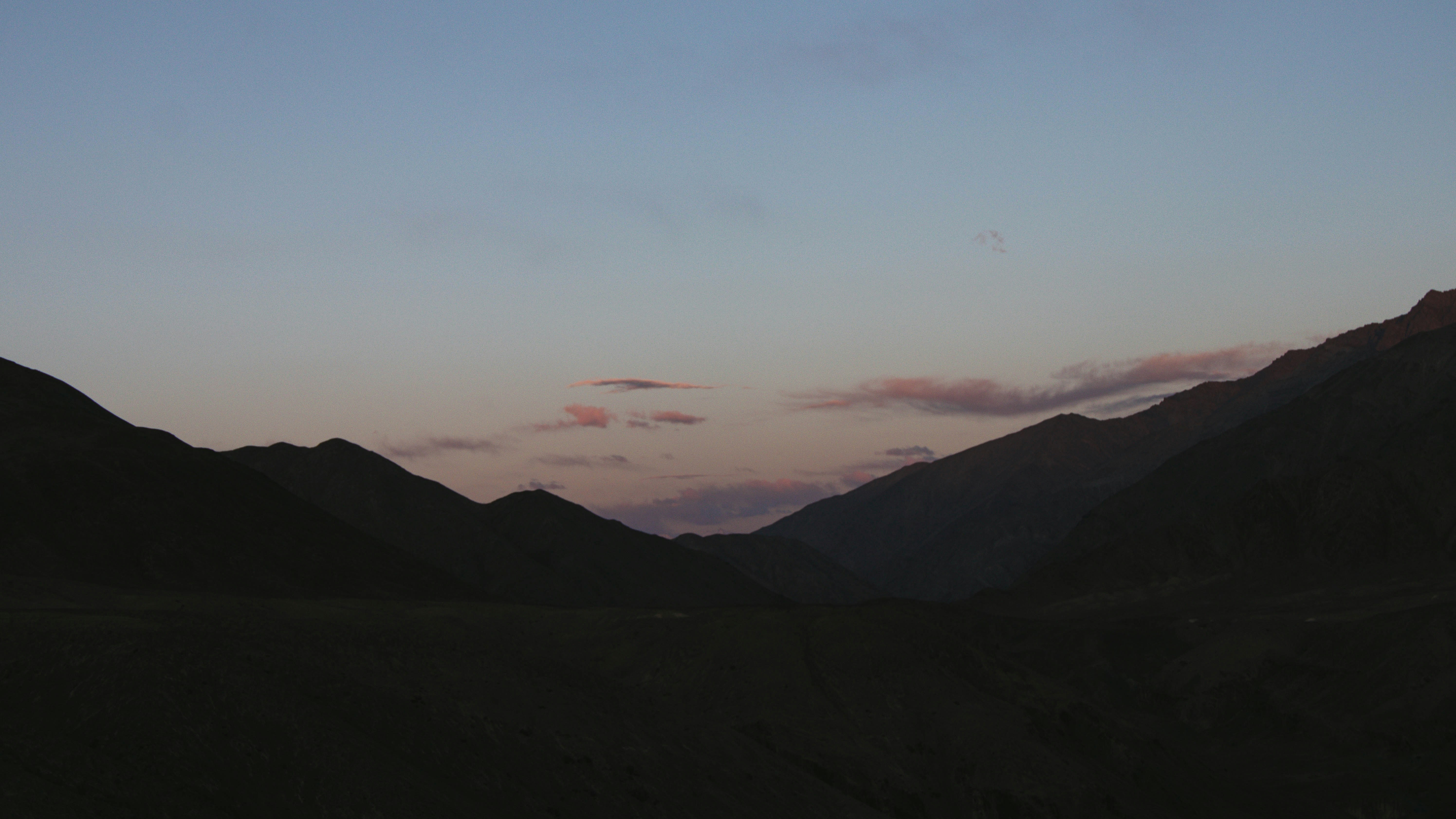 Twilight Valley: Shadowed Peaks Beneath a Pale Dusk