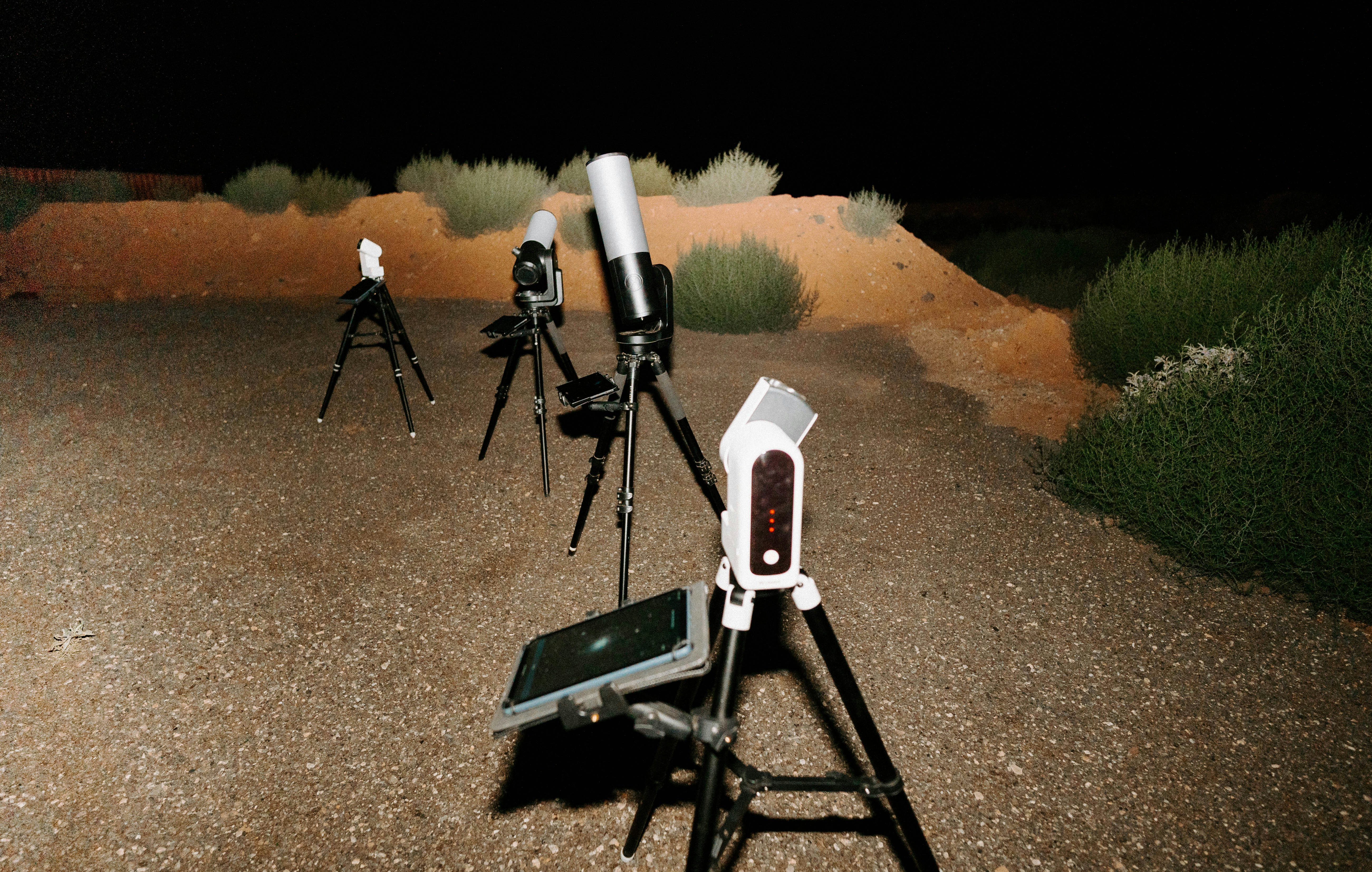 Night Field of Reach: A Row of Telescopic Tripods Anchoring the Desert