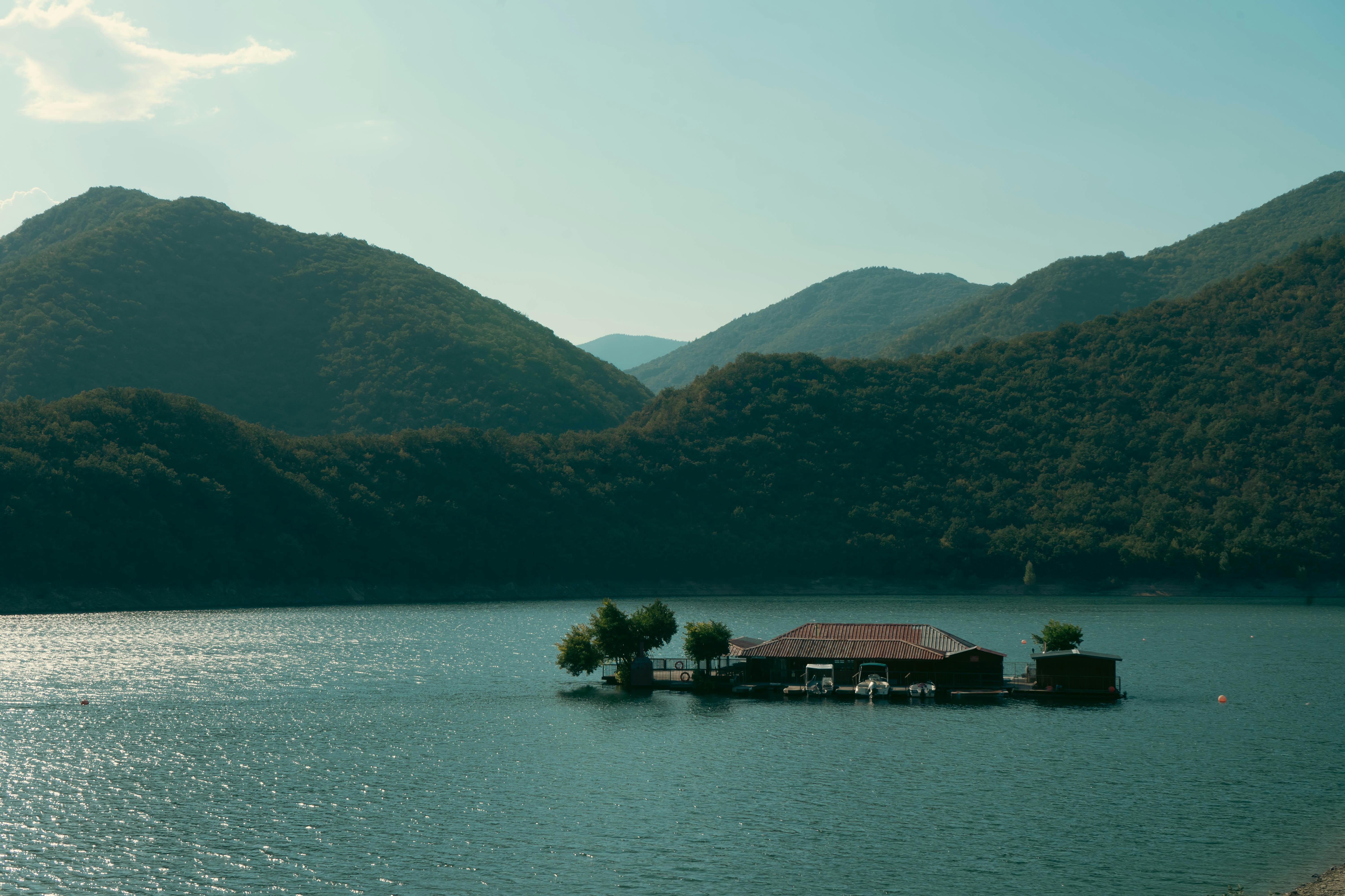 Floating refuge on a tranquil lake framed by emerald hills