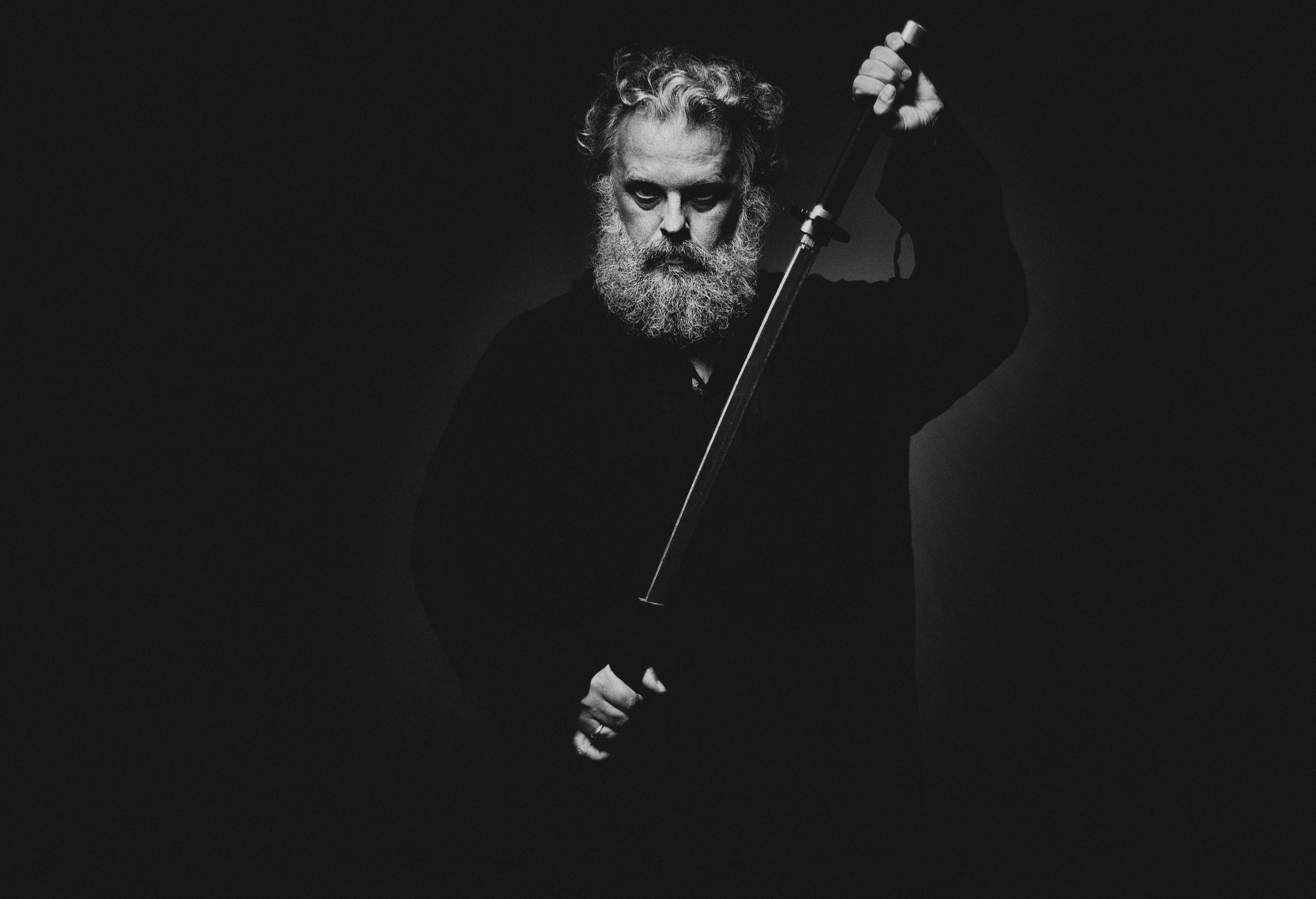 Silent Vigil: The Bearded Maestro with the Raised Blade