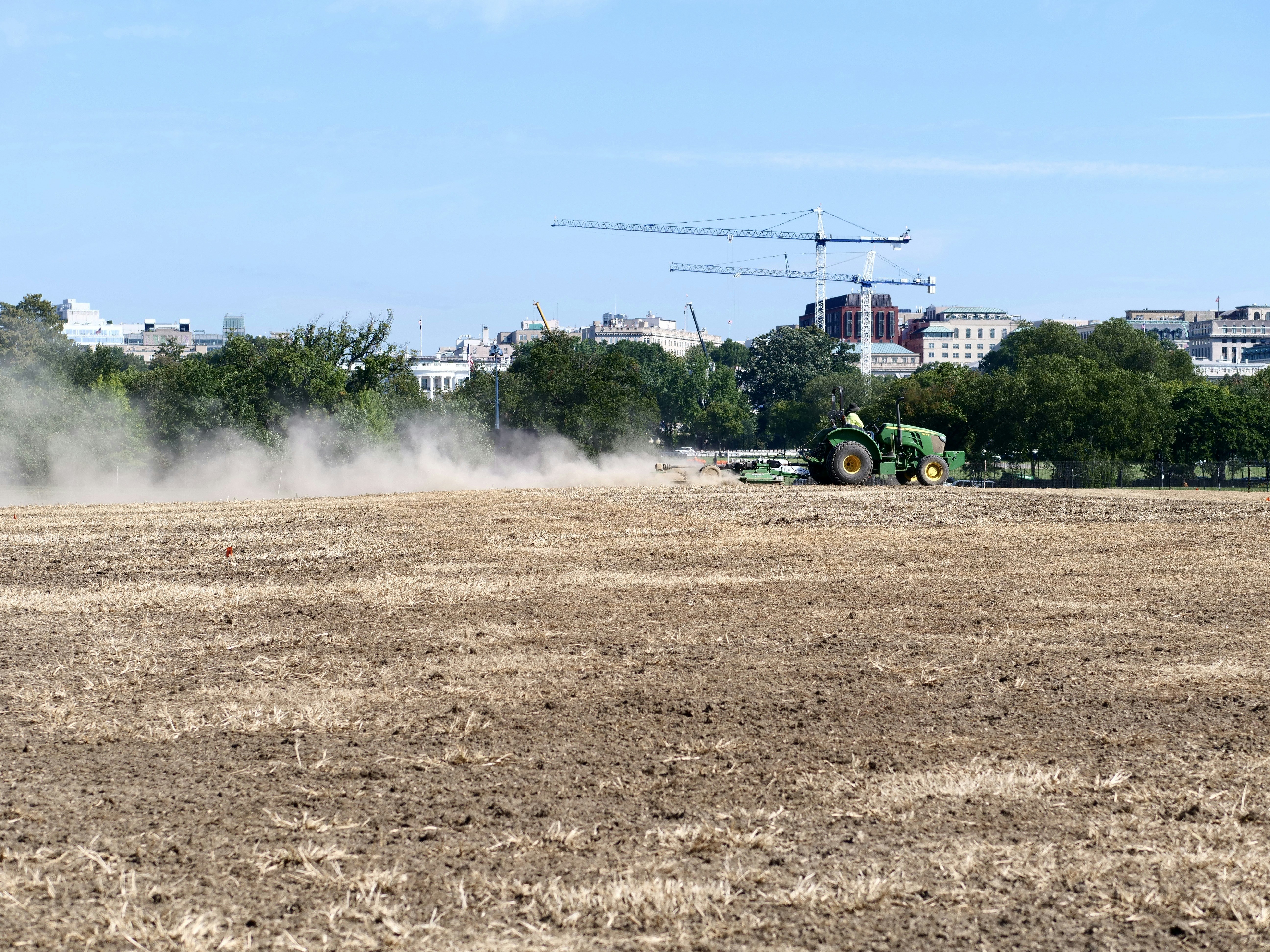 Dust Trail and Tractor: Field Perspective Under a Busy Sky