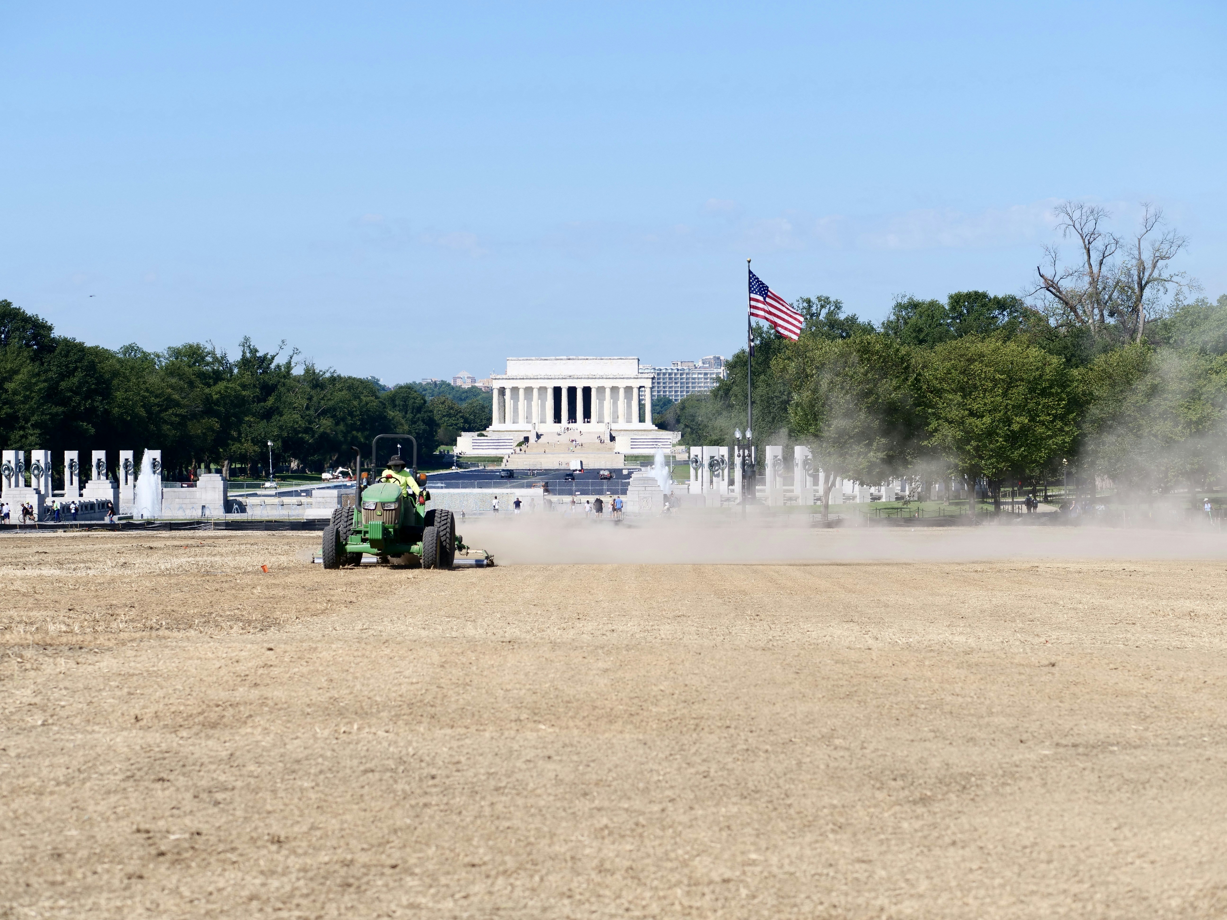 Dusty parade: Treads and a distant Capitol shadow