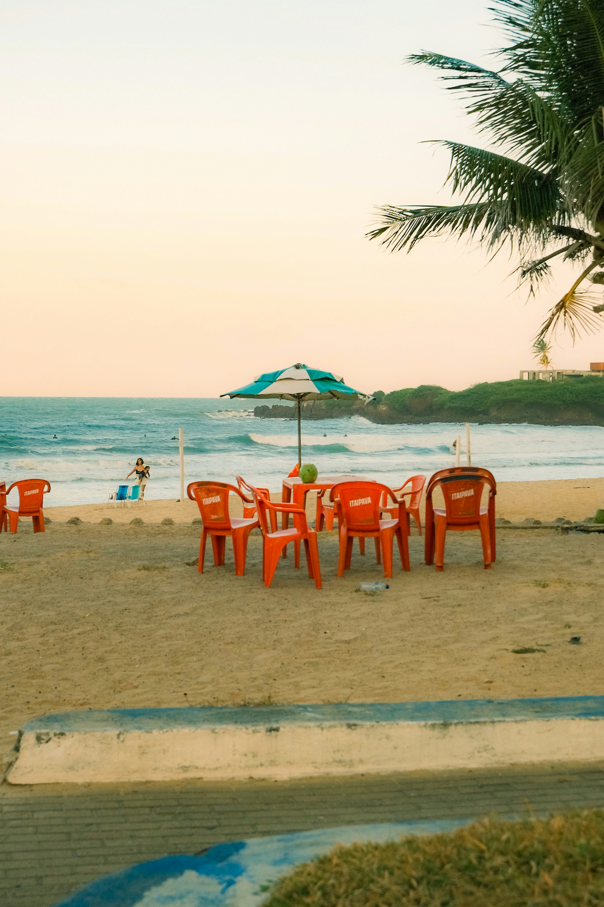 Sunlit Beach Picnic: Orange Chairs and Quiet Surf