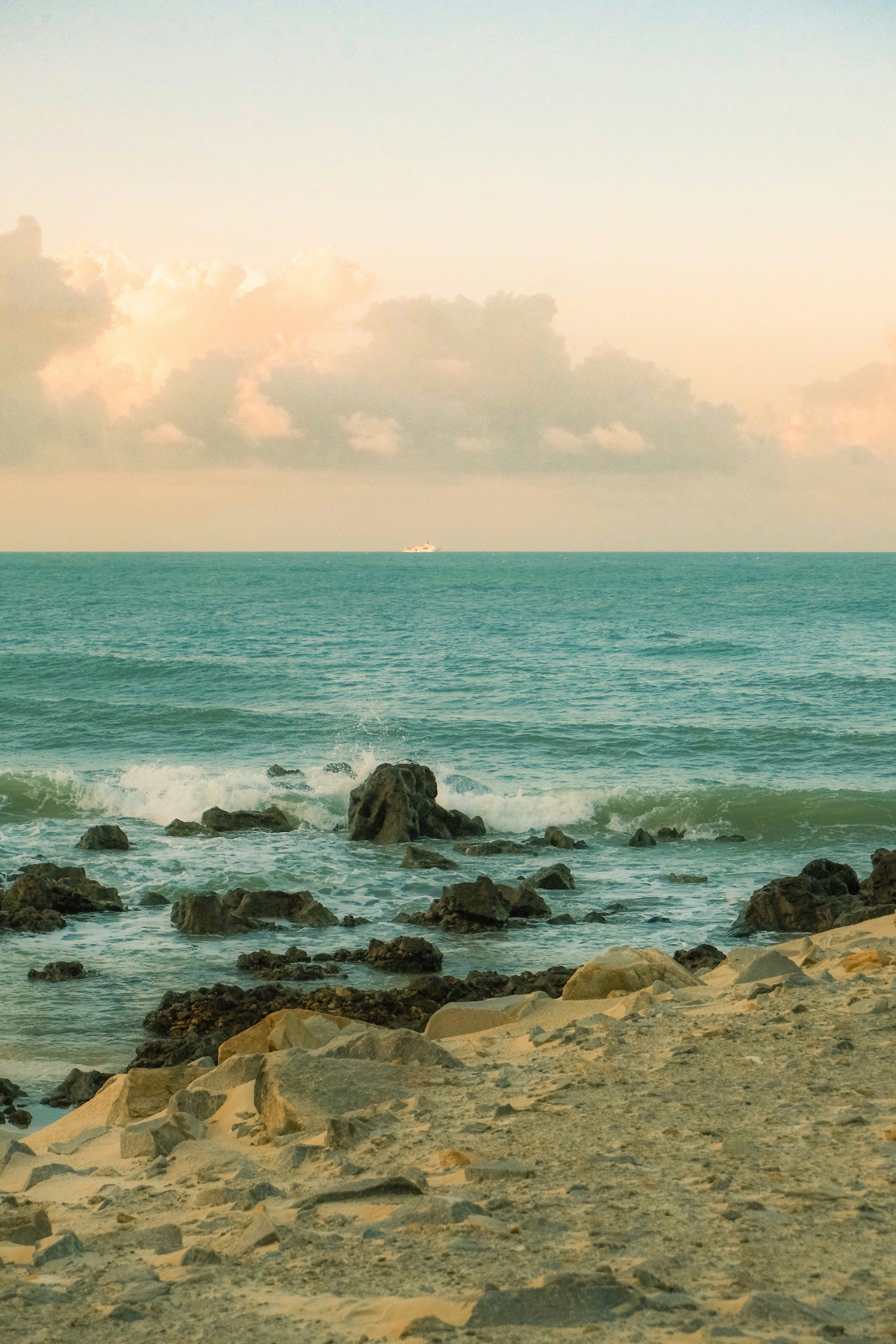 Sunlit Shoreline: Quiet Horizon and Weathered Rocks
