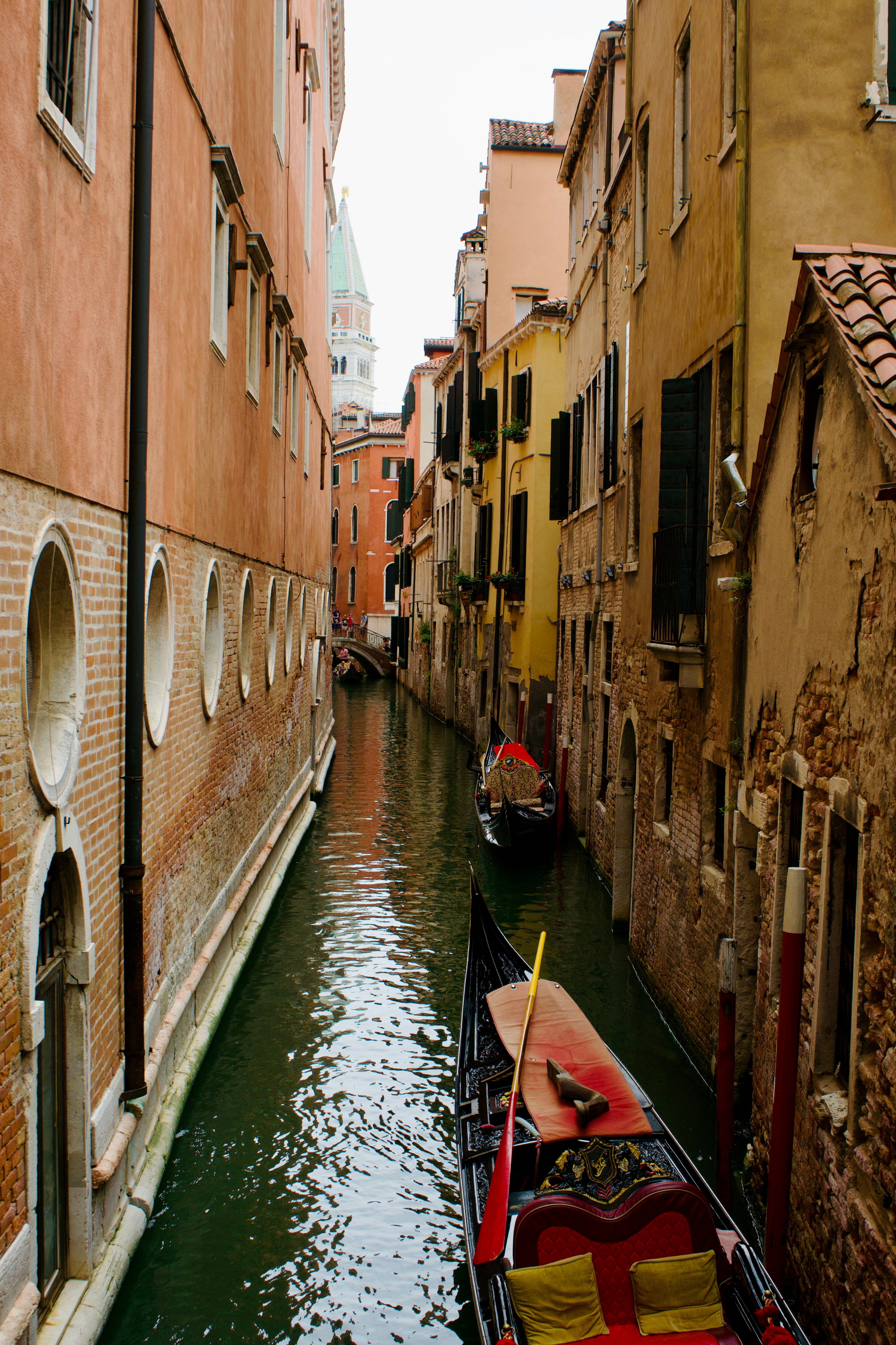 Gondola Lane: Sunlit Canal Between Colorwashed Facades