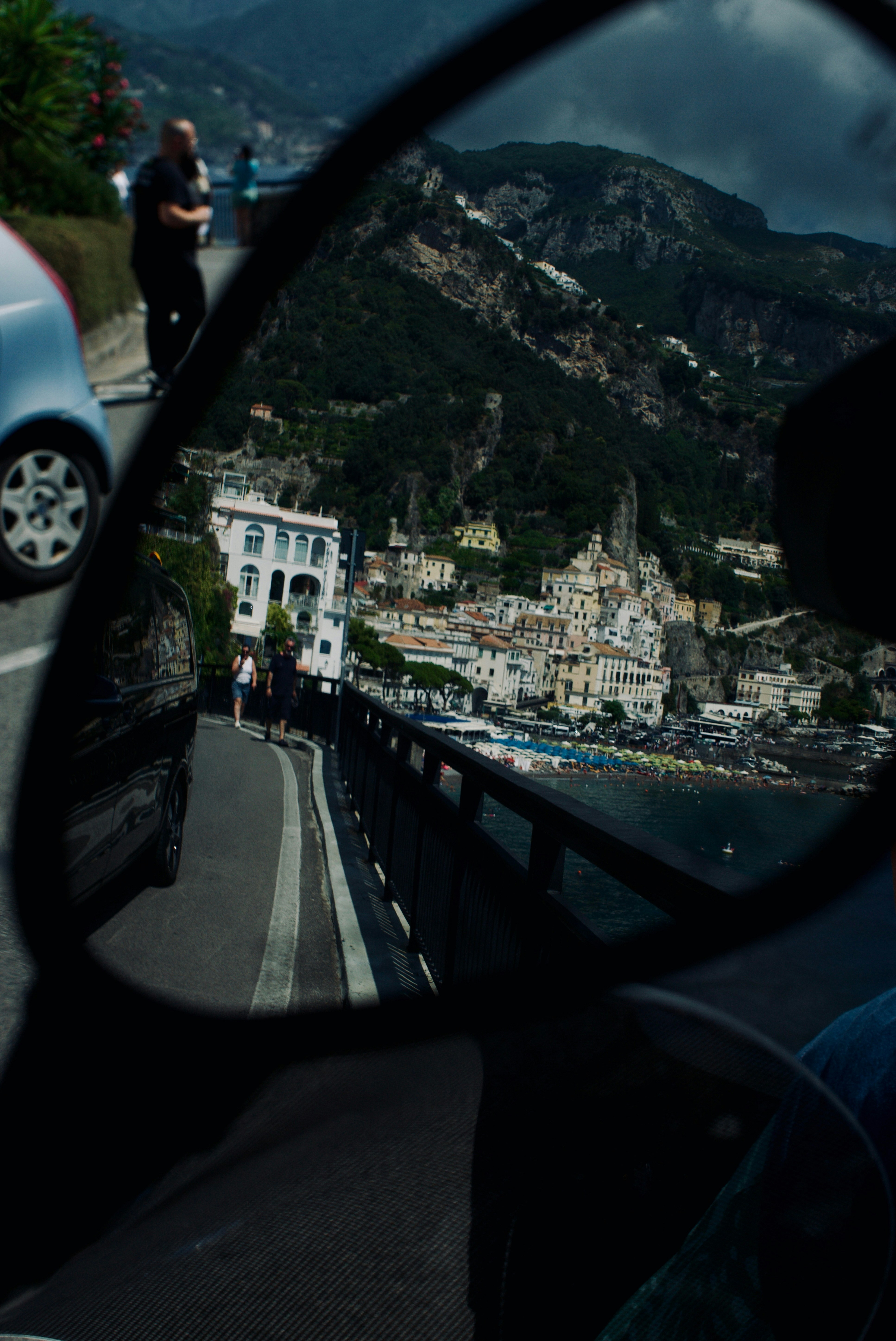 Through the Lens: Village by the Dolomitic Shore Reflected in a Car Mirror
