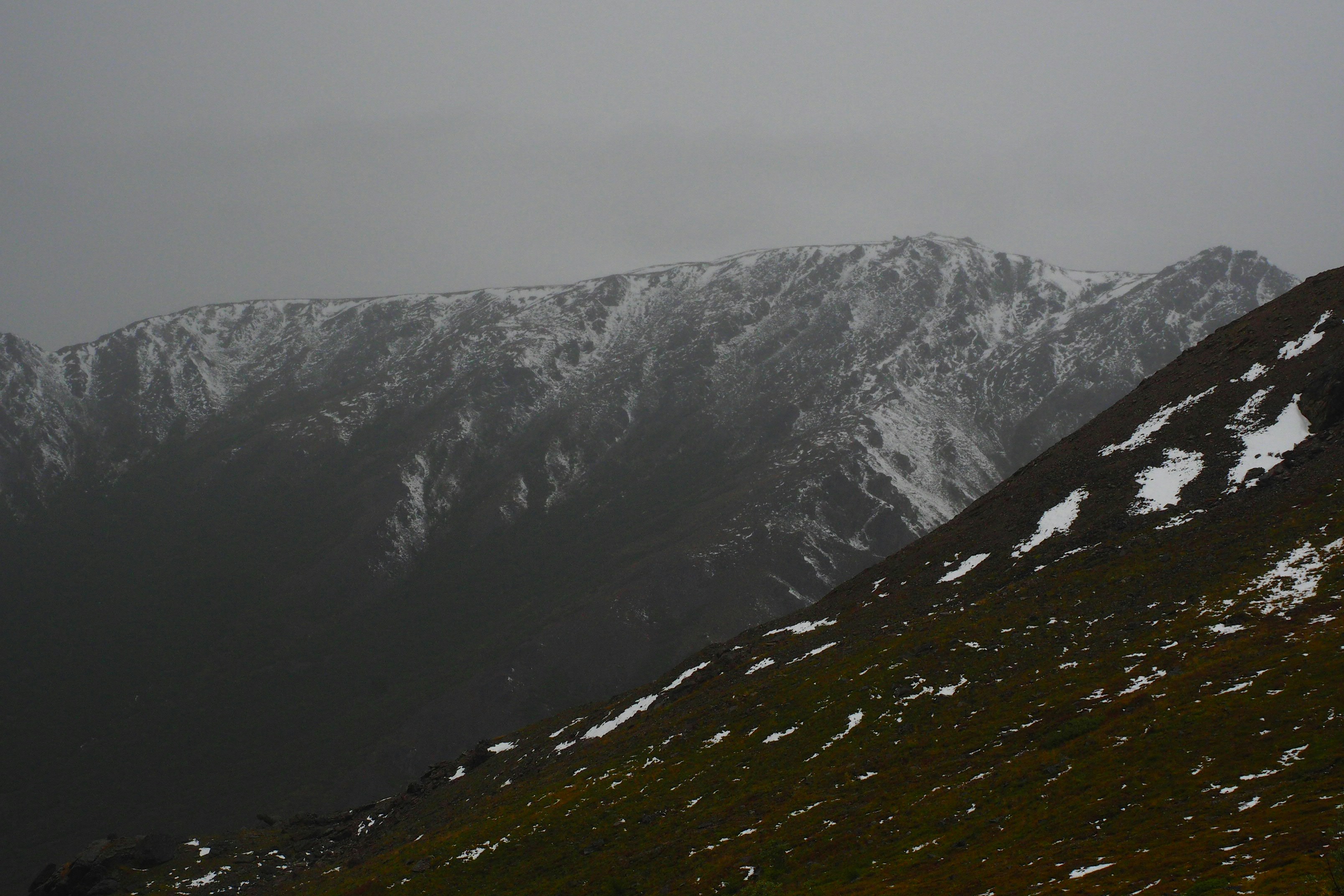 Snow-veiled Ridge against a moody alpine valley
