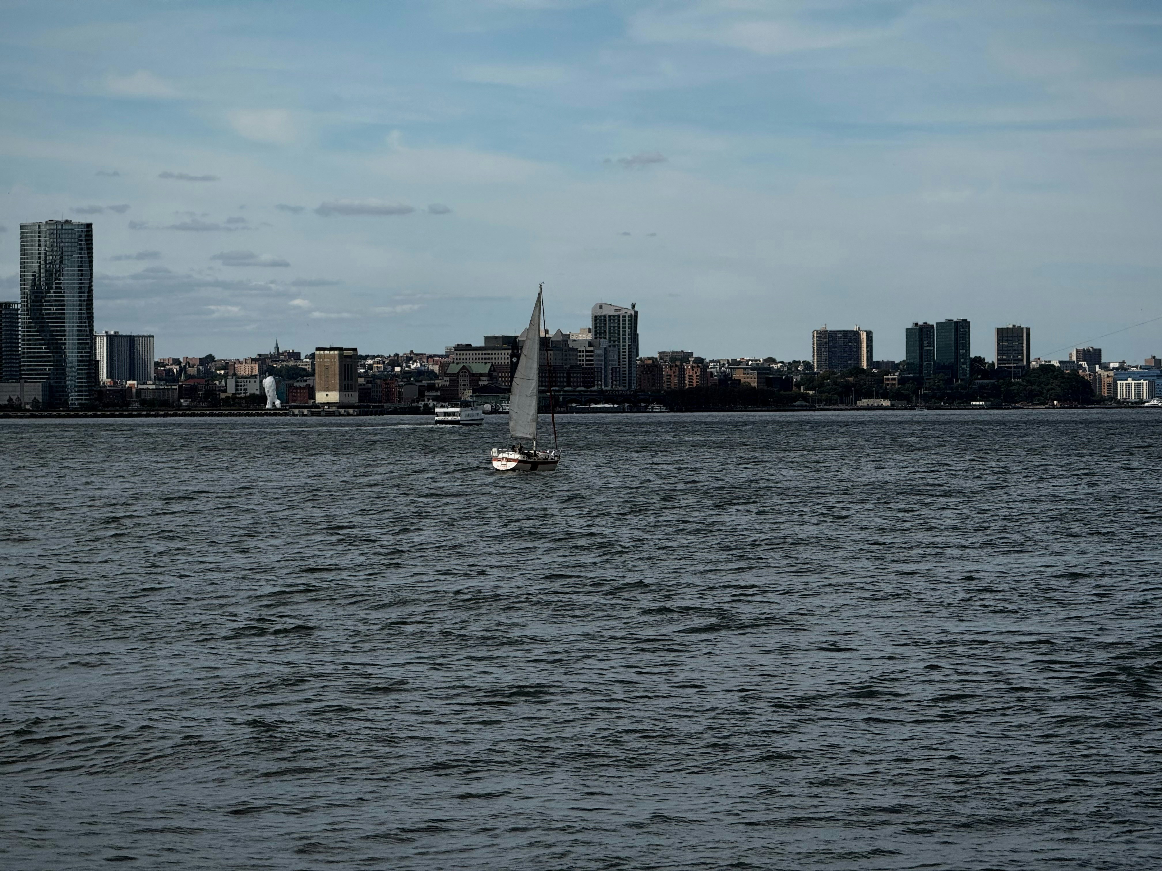 Sailboat Cleaving the Calm Toward a Modern Shore
