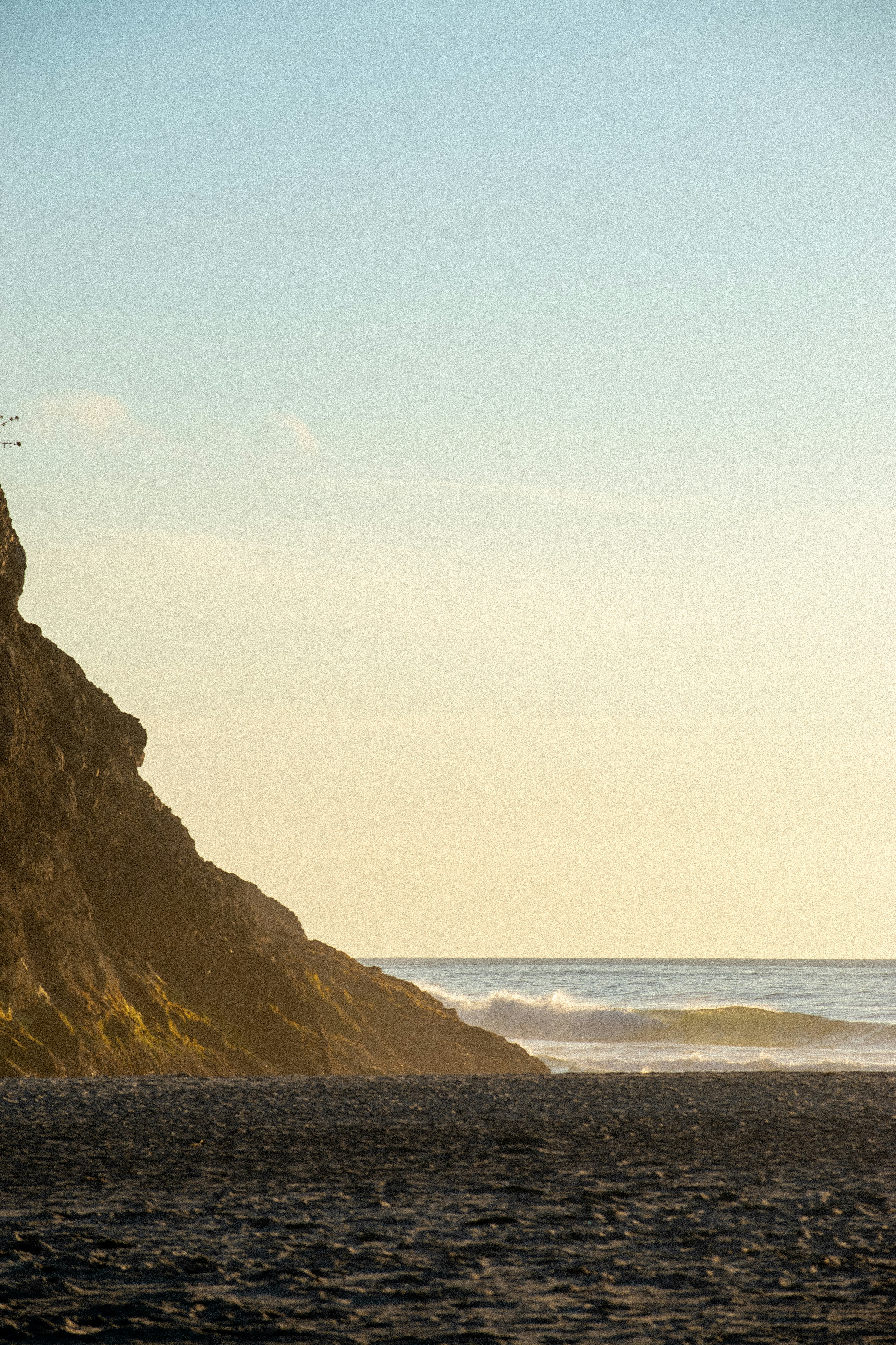 Coastal Light on a Quiet Beach: Cliffline Meets Distant Sea