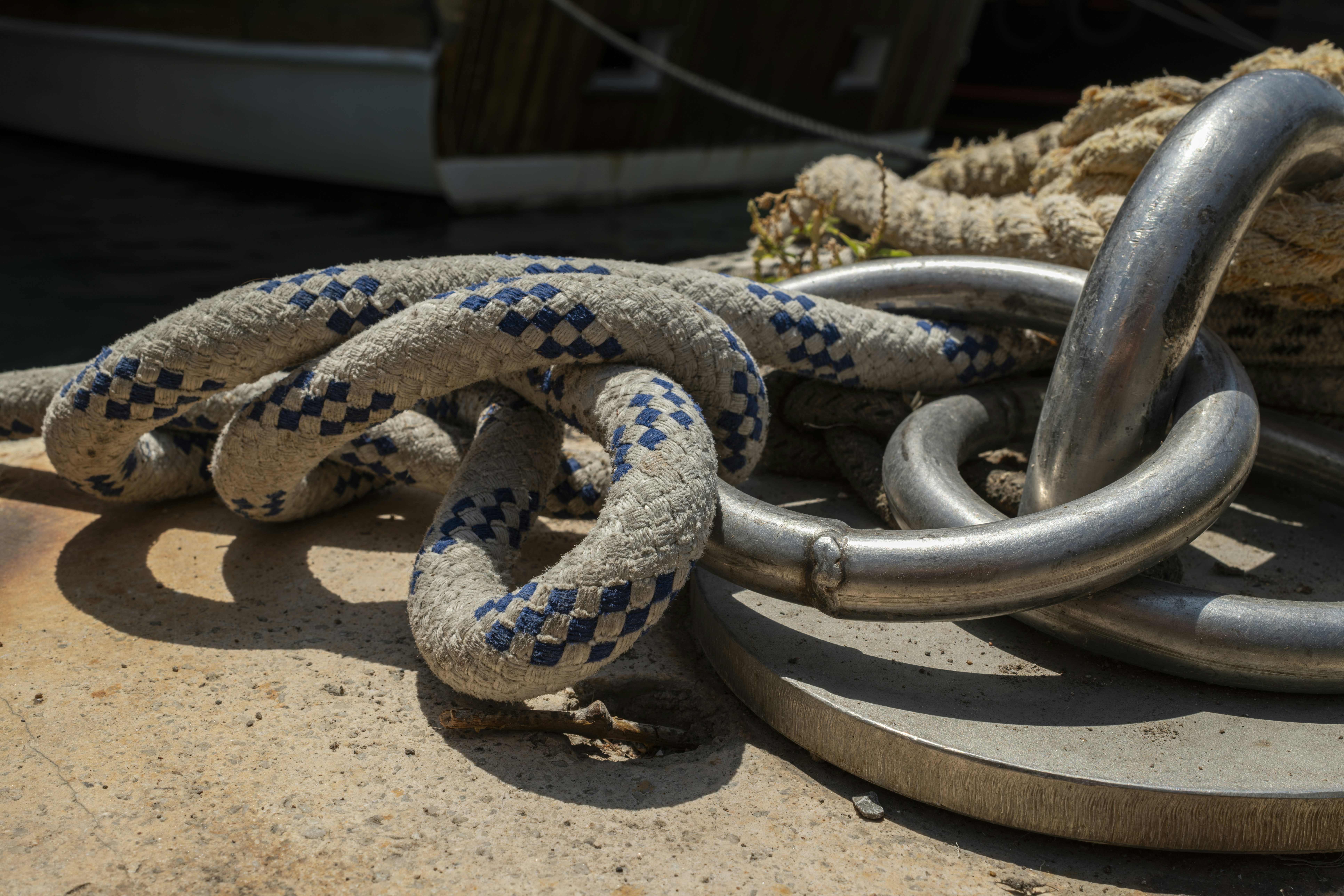 Tangled lines of rope and metal in a sunlit dock