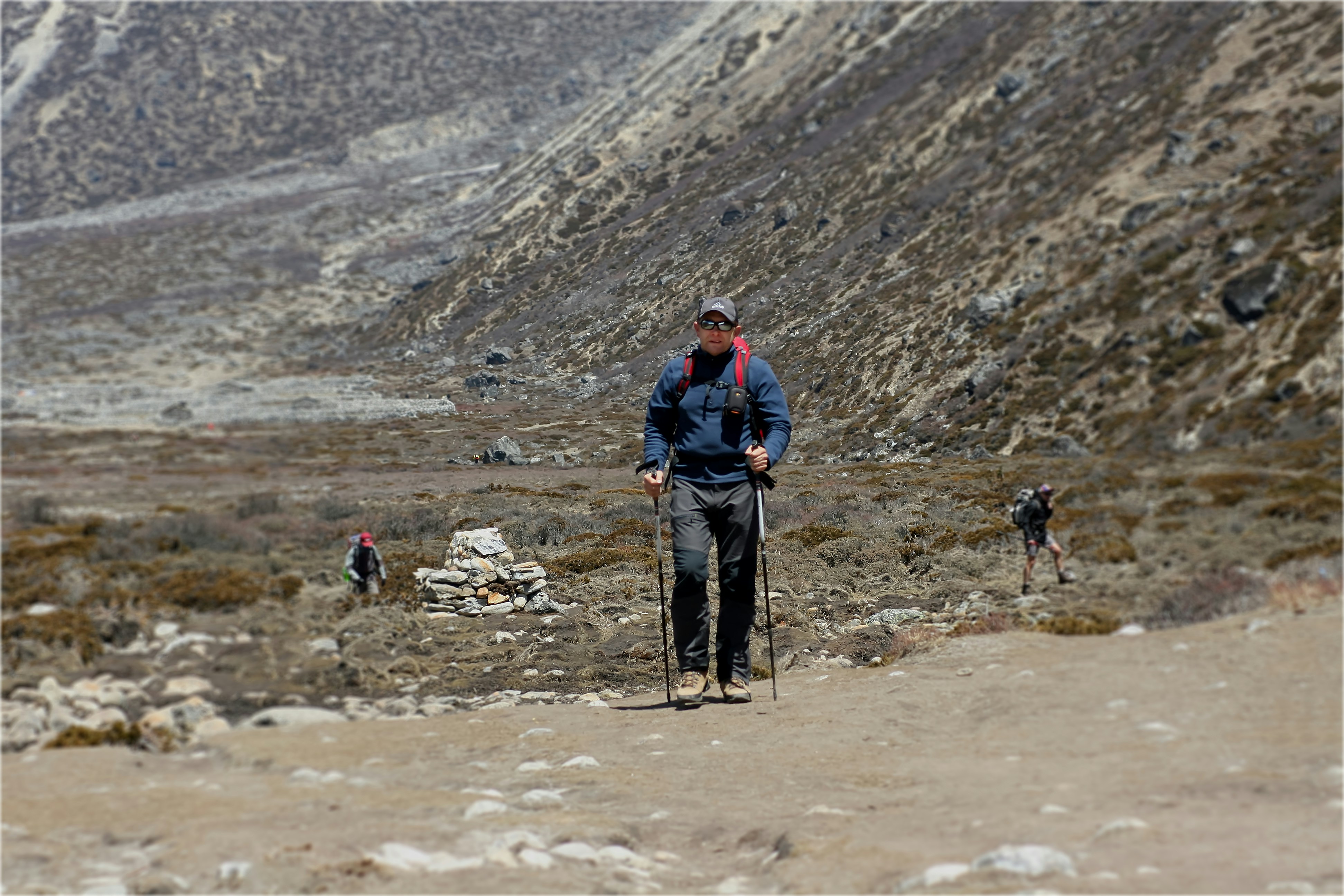 Rolling trekker in a stark alpine basin