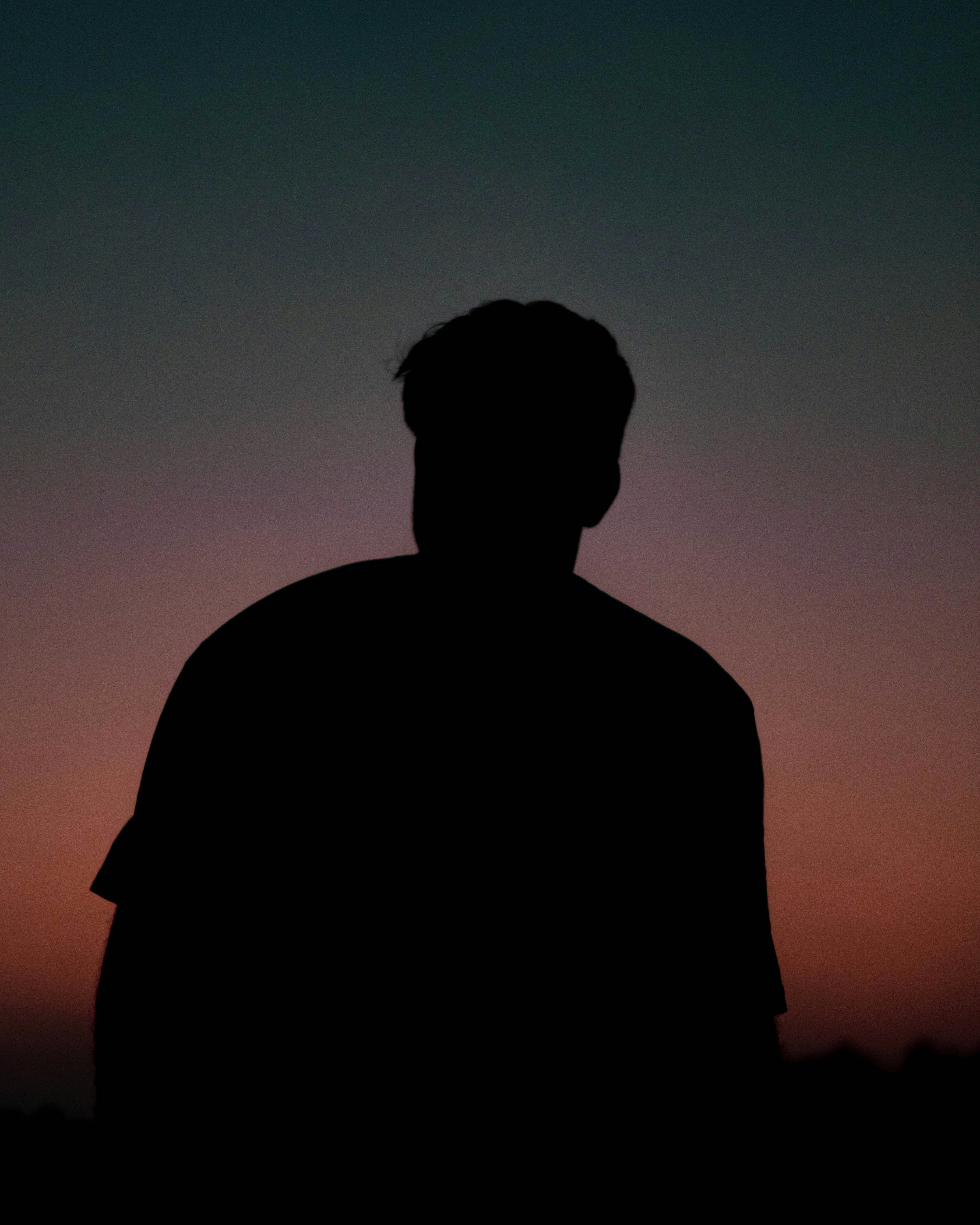 Silhouette at Dusk: A Looming Figure Against a Velvet Sky