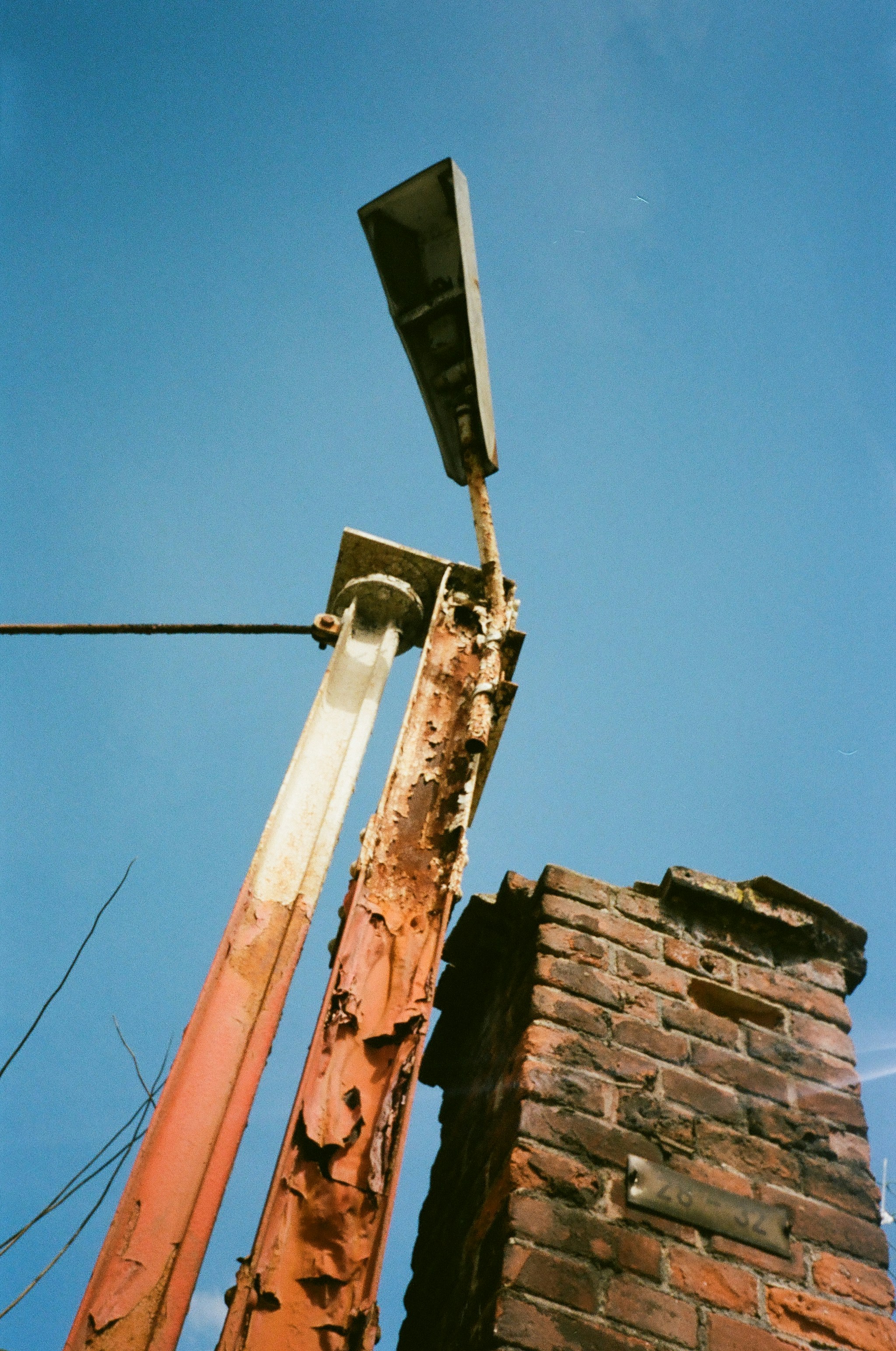 Rusted Crane Arm Rising Against a Clear Blue Sky