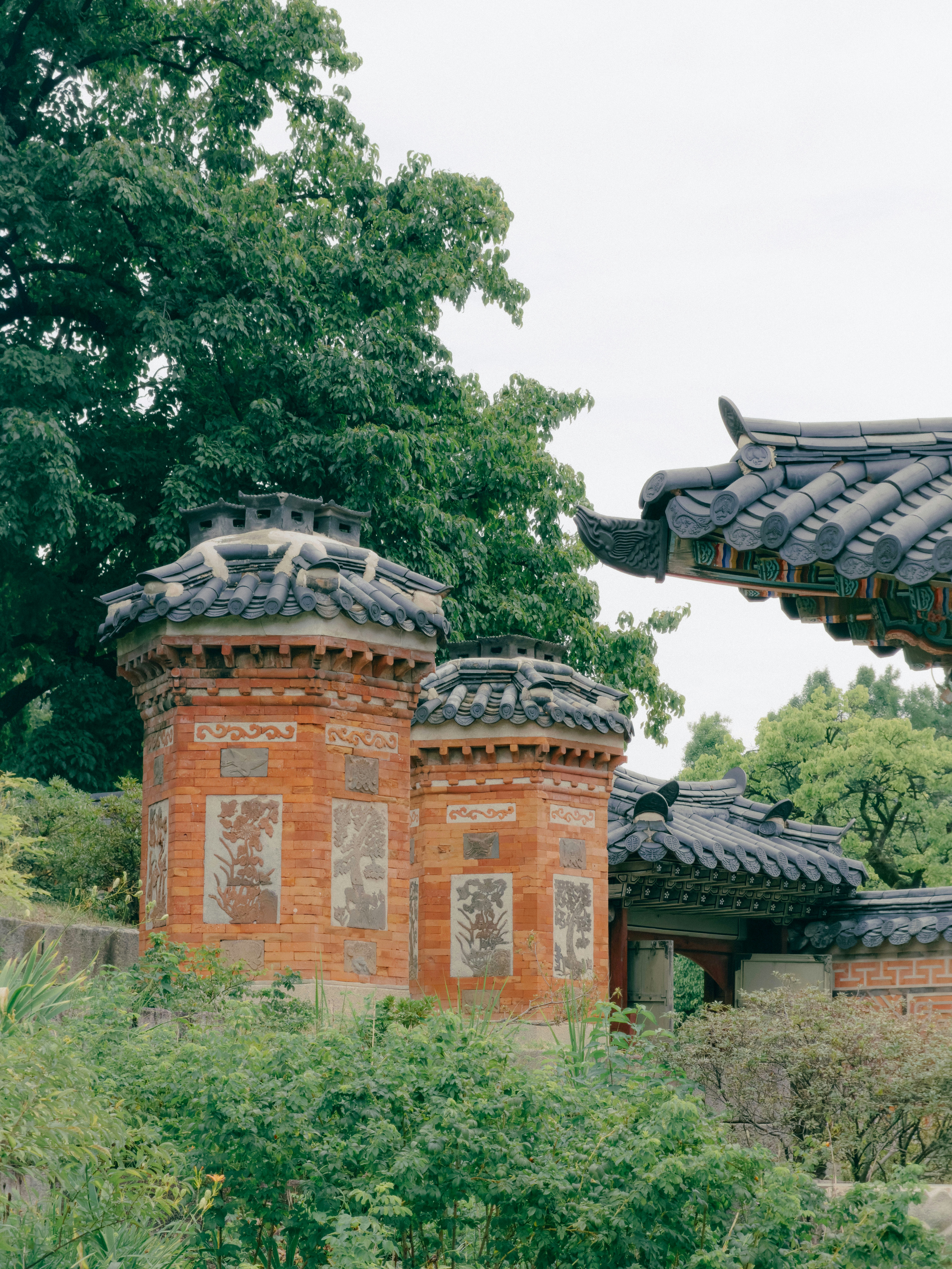 Brick gate towers under tiled eaves in a tranquil Korean-style courtyard