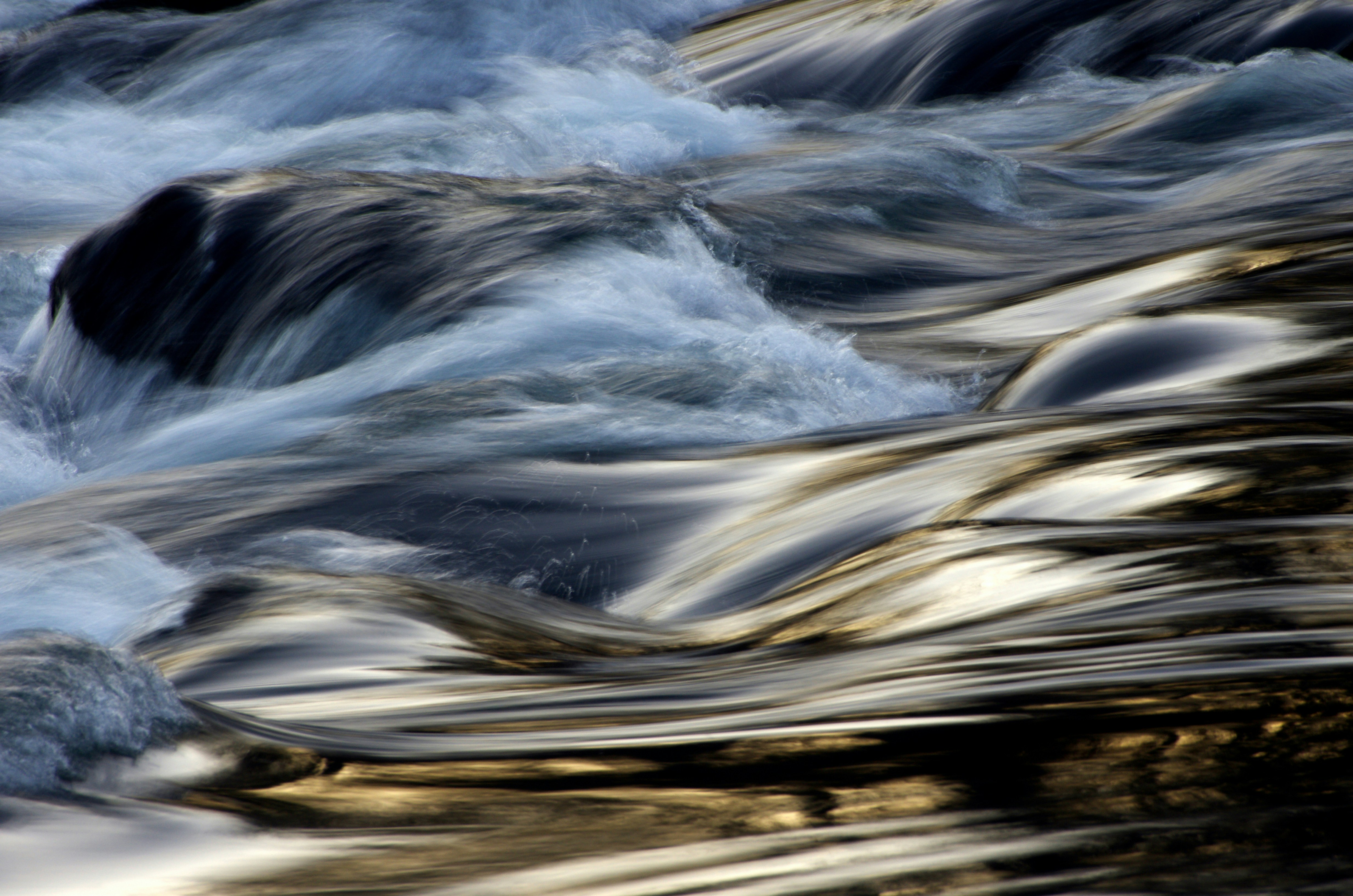 Liquid Gleam: Golden-Bed River Light Weaving Through Flowing Currents