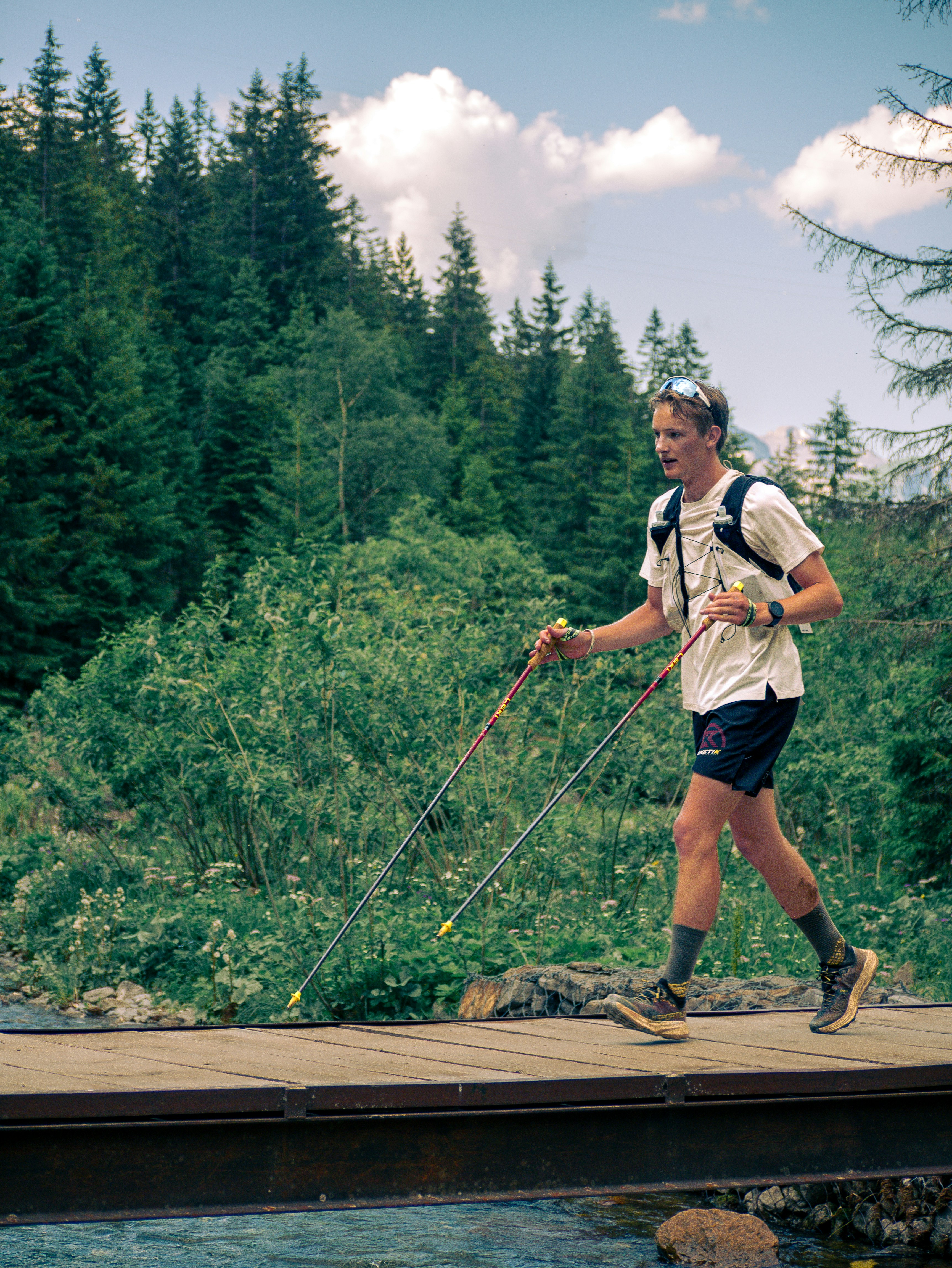Trail Runner on a Wooden Crossing Over a Swift River