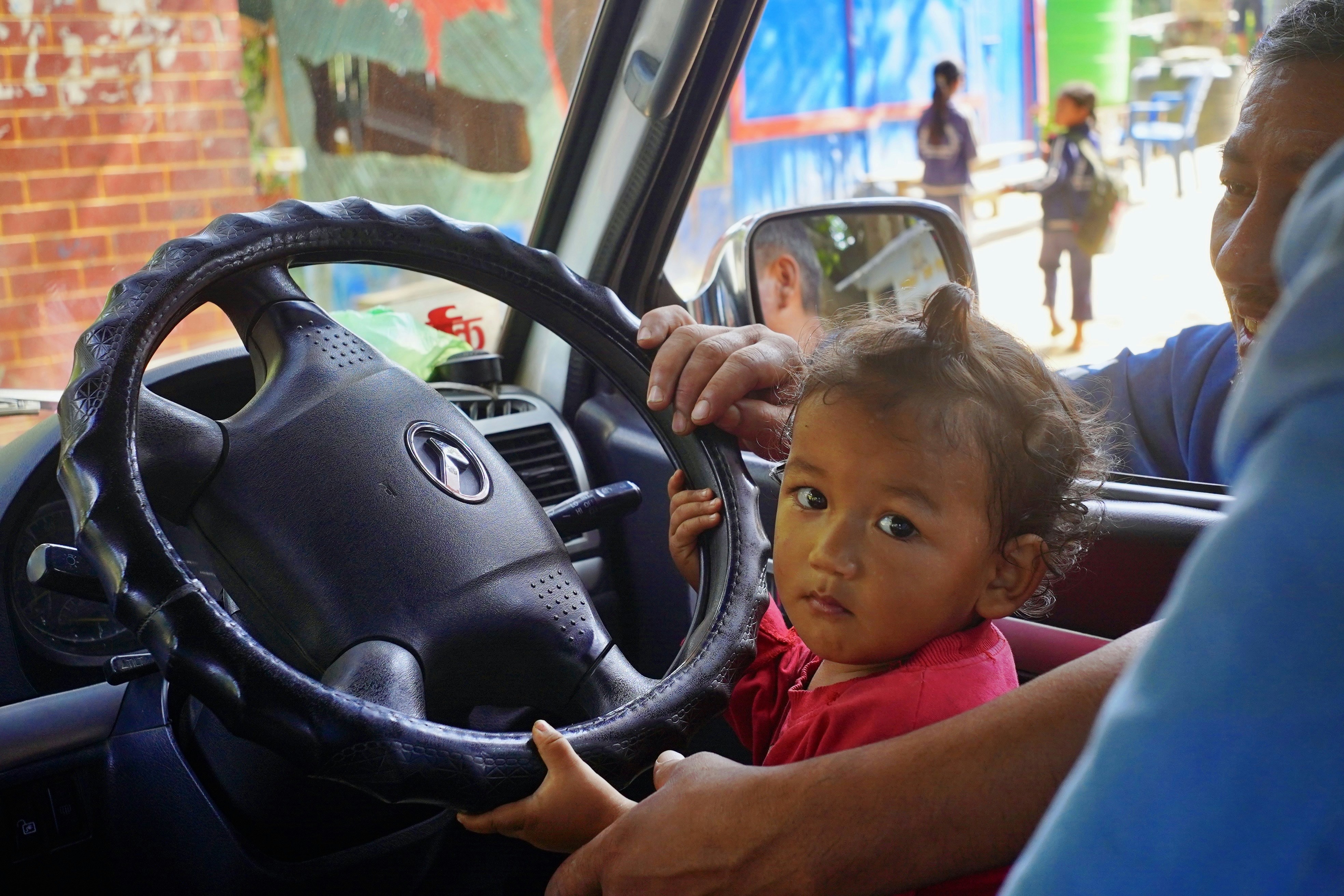 Eyes on the Small Passenger: A Kid Clutching the Steering Wheel