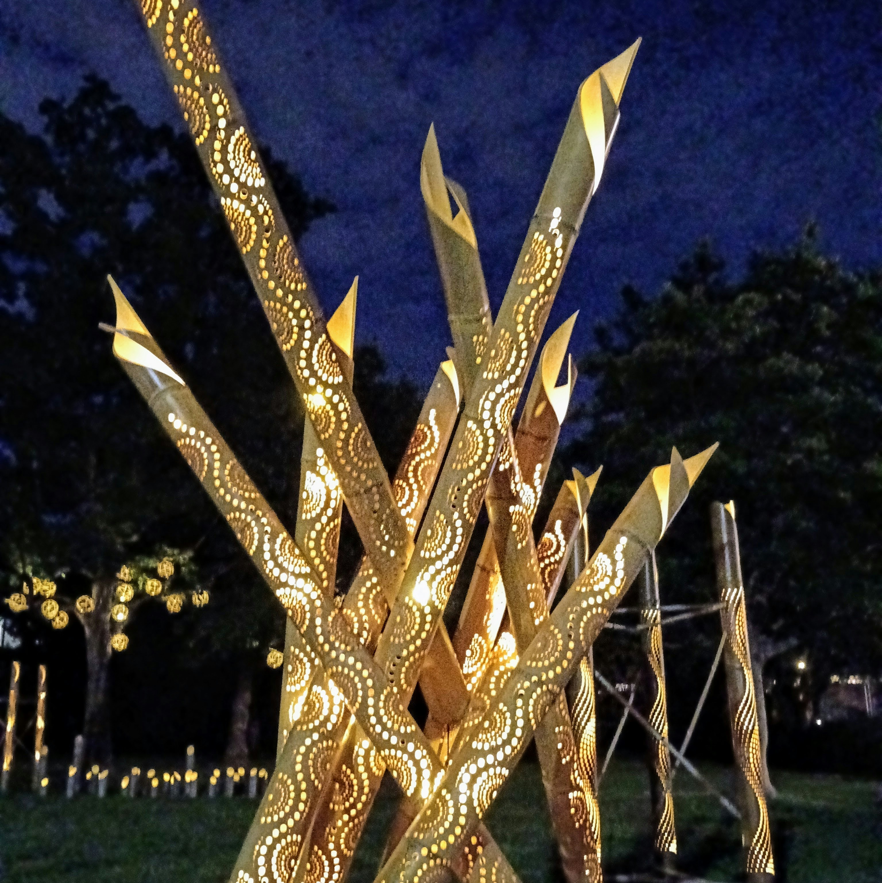 Luminous Origami Pines: Night sculpture in a park