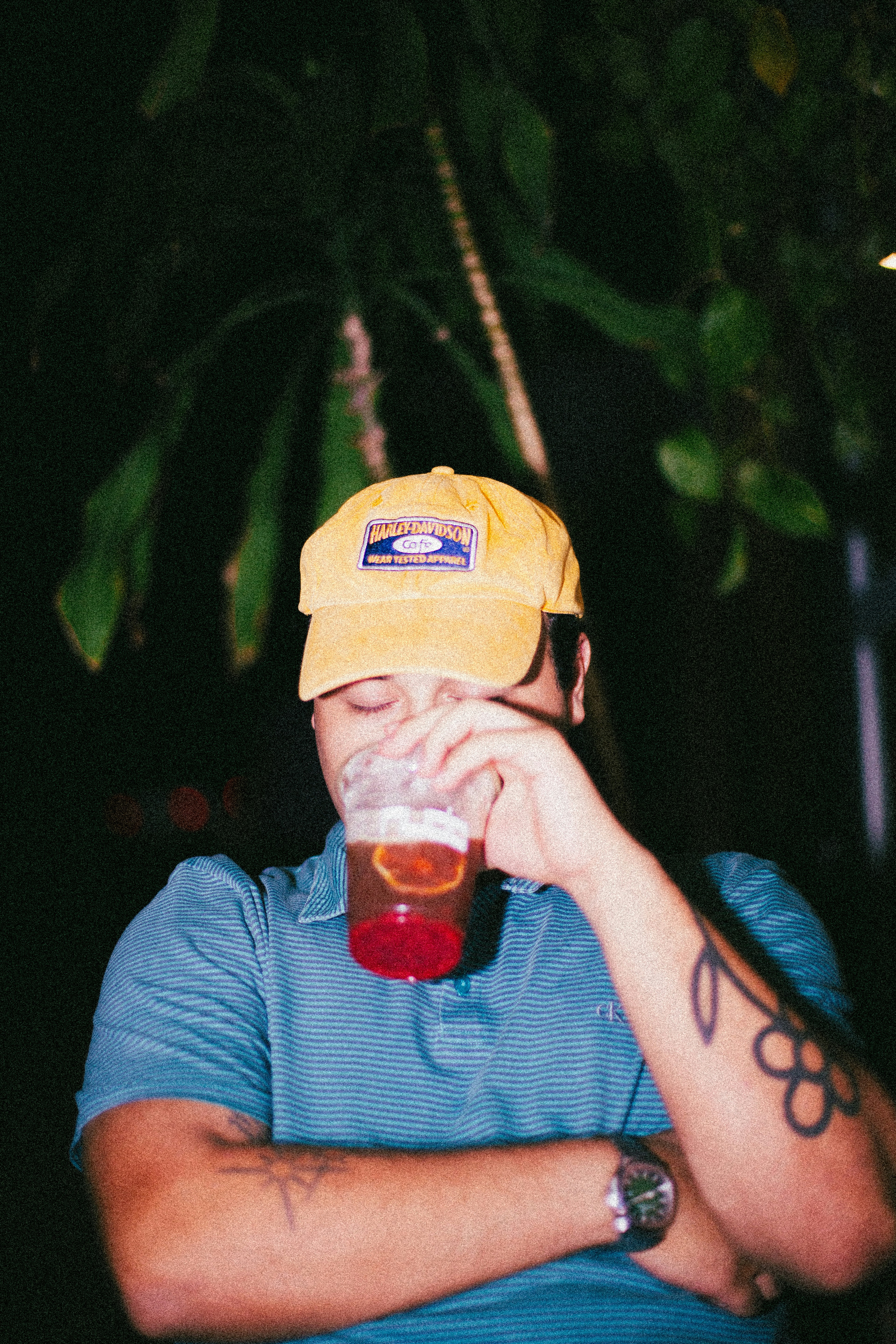 Yellow Cap, Red Drink, Night Life: Quiet Confidence in a Backlit Moment