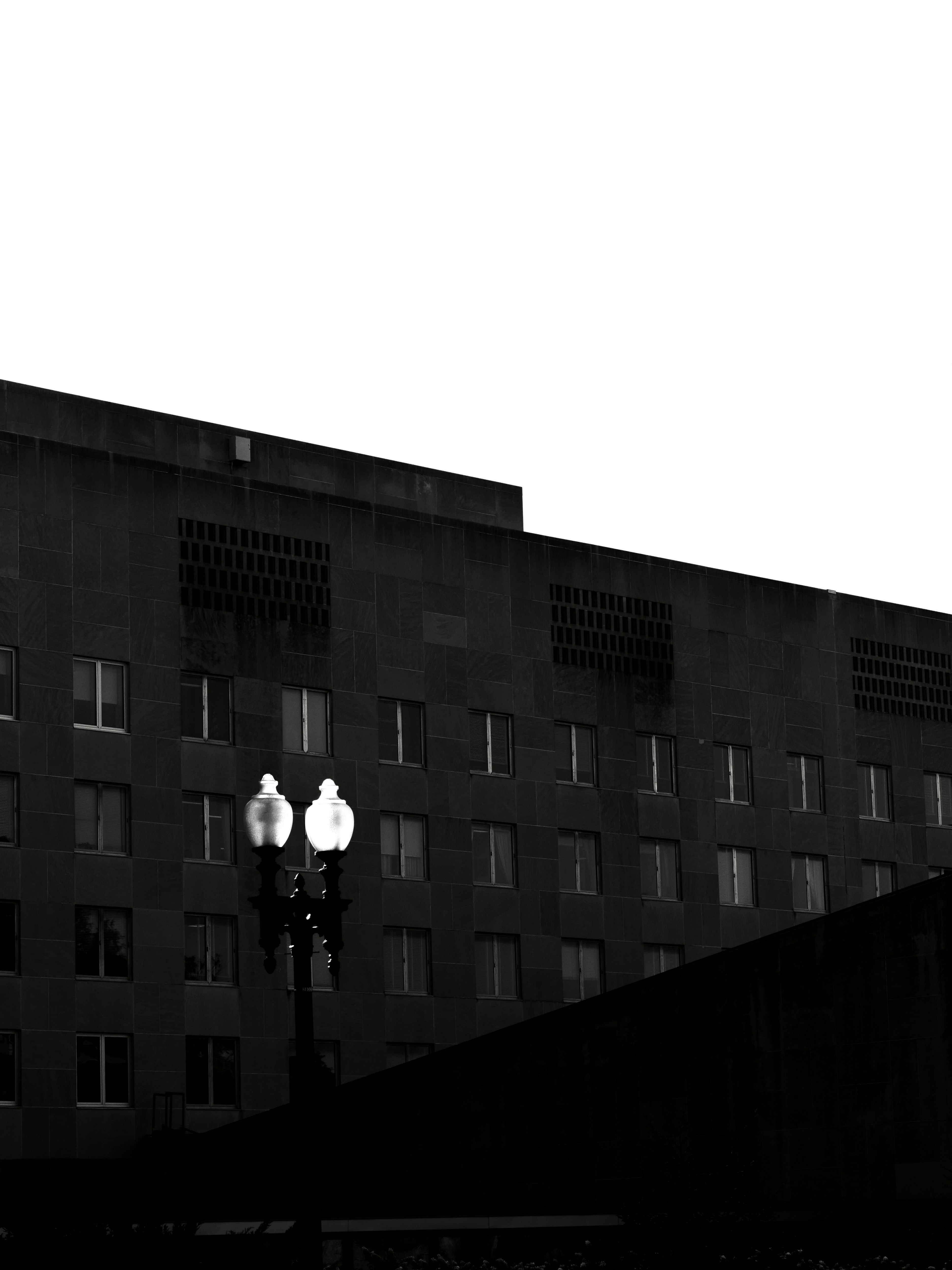 Midnight Facade: A Lone Street Lamp against a Monochrome Building