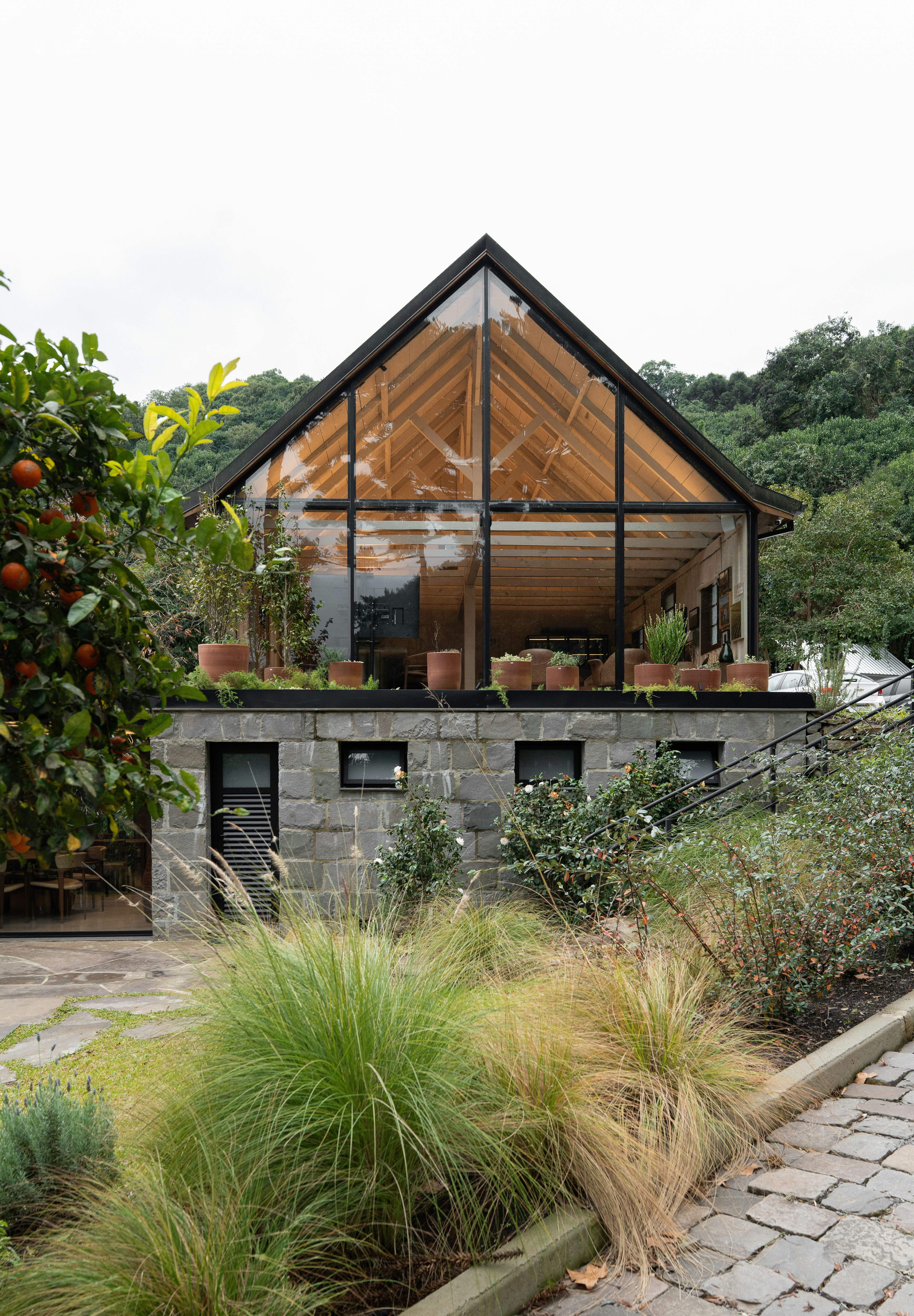 Glass-Clad Conservatory Rising from Stone Terrace