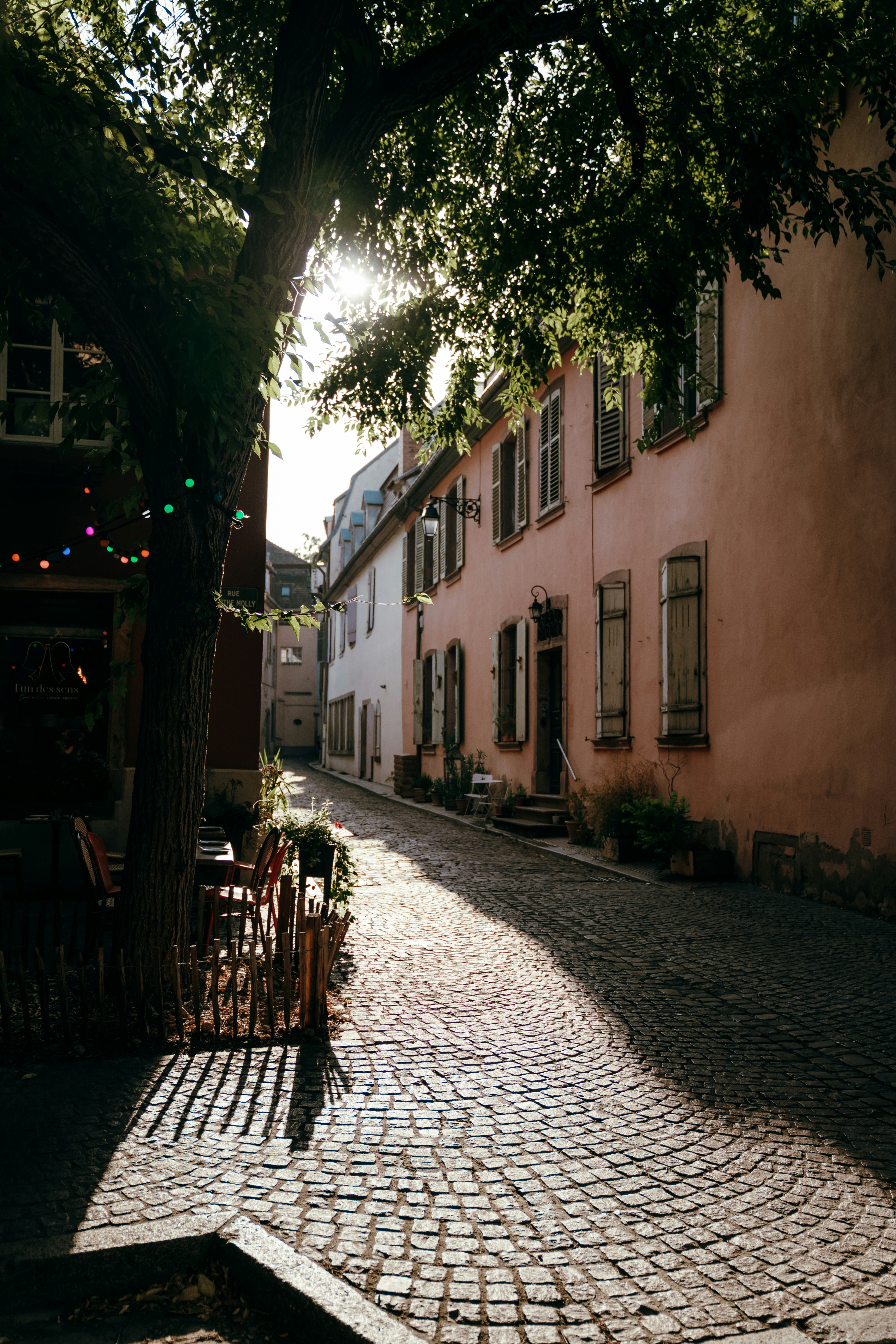 Sunlit Alley: A Cobblestone Path Between Warm Facades