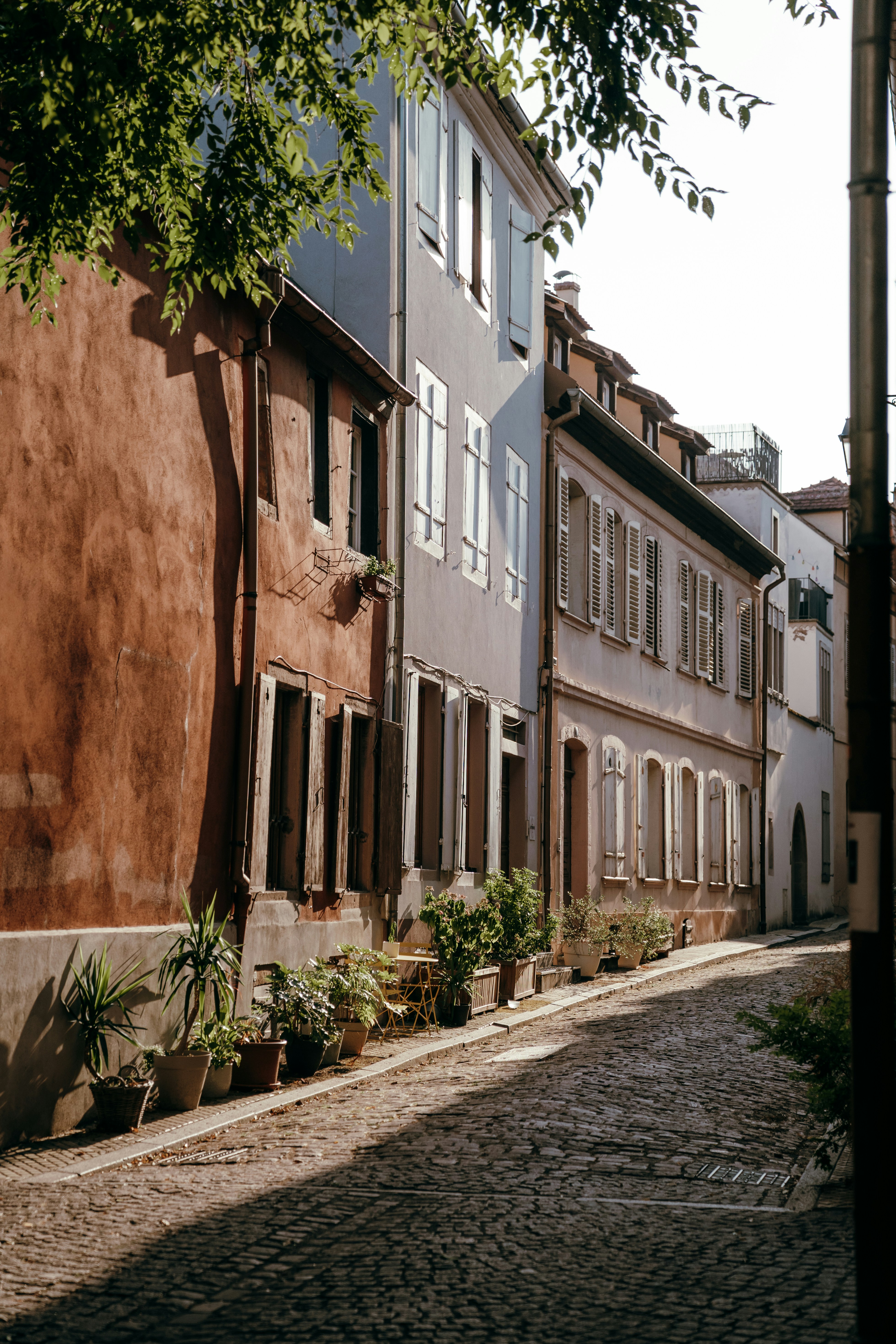 Sunlit Cortile: A Quiet European Alley in Warm Clay and Blue Facades