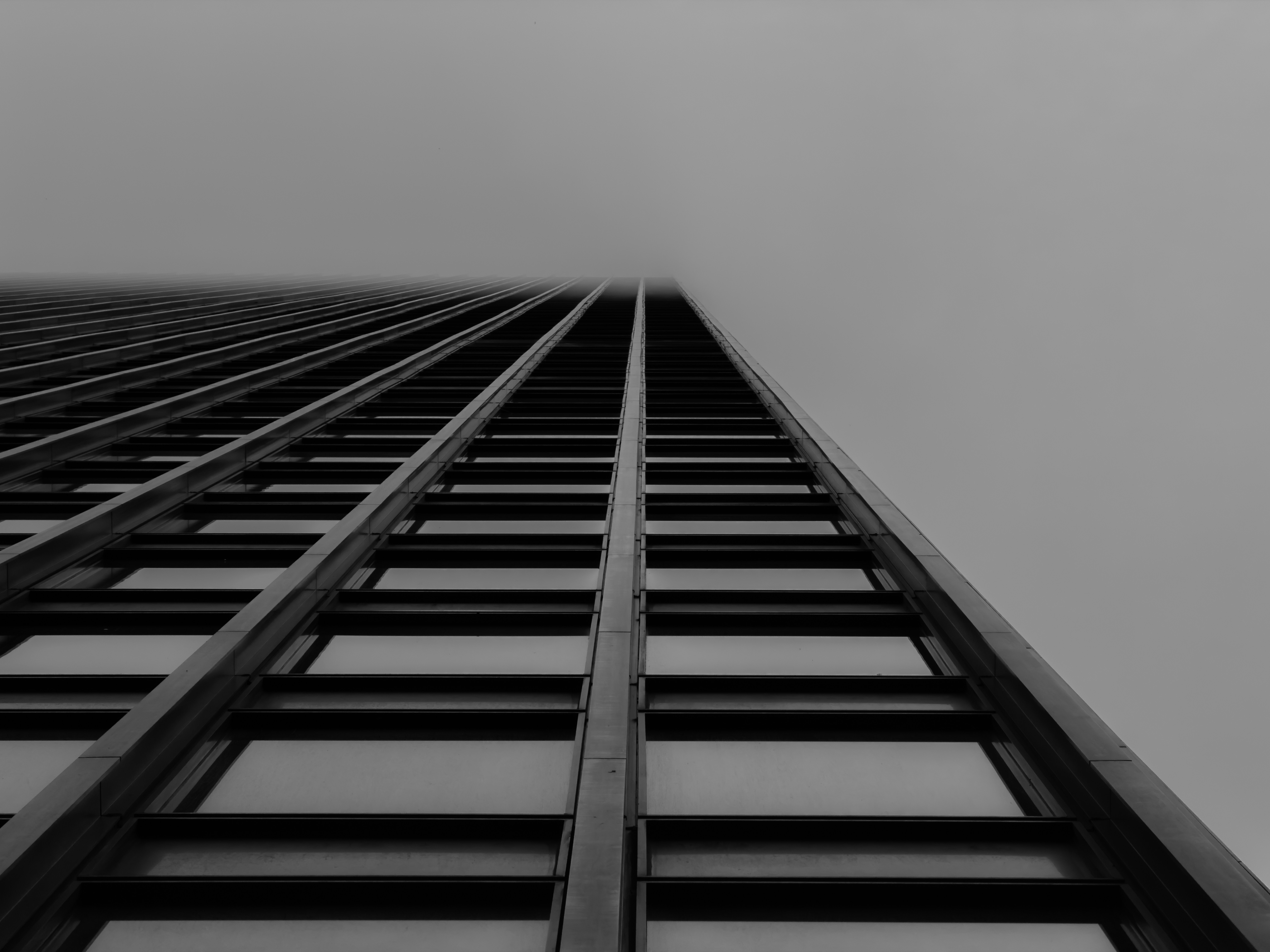 Tall Glass and Sky: A Monochrome Ascent Up a Facade