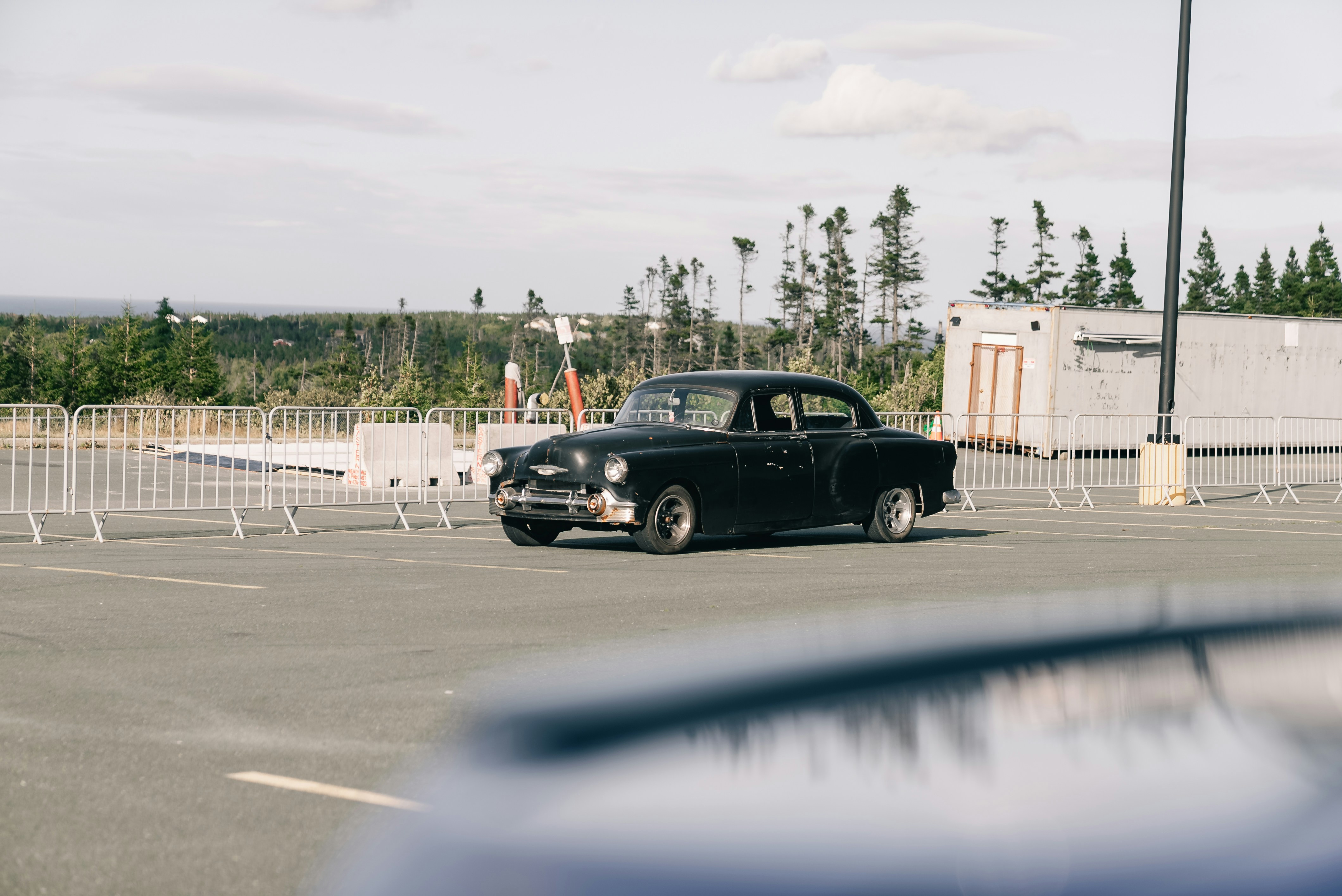 Midday Parade: A Vintage Car at the Edge of an Empty Lot