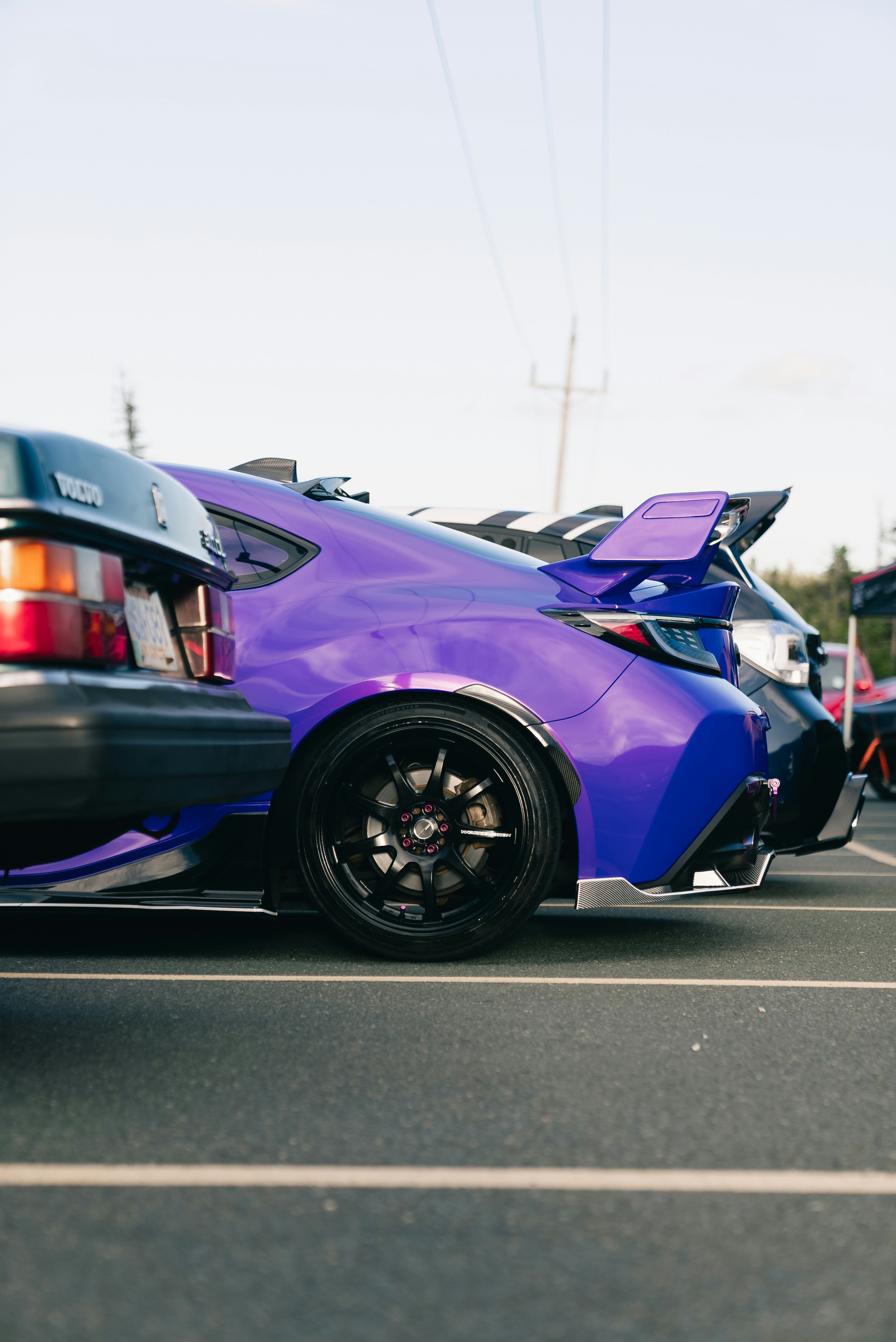Vibrant purple drift machine: rear-quarter profile in a sunlit parking lot