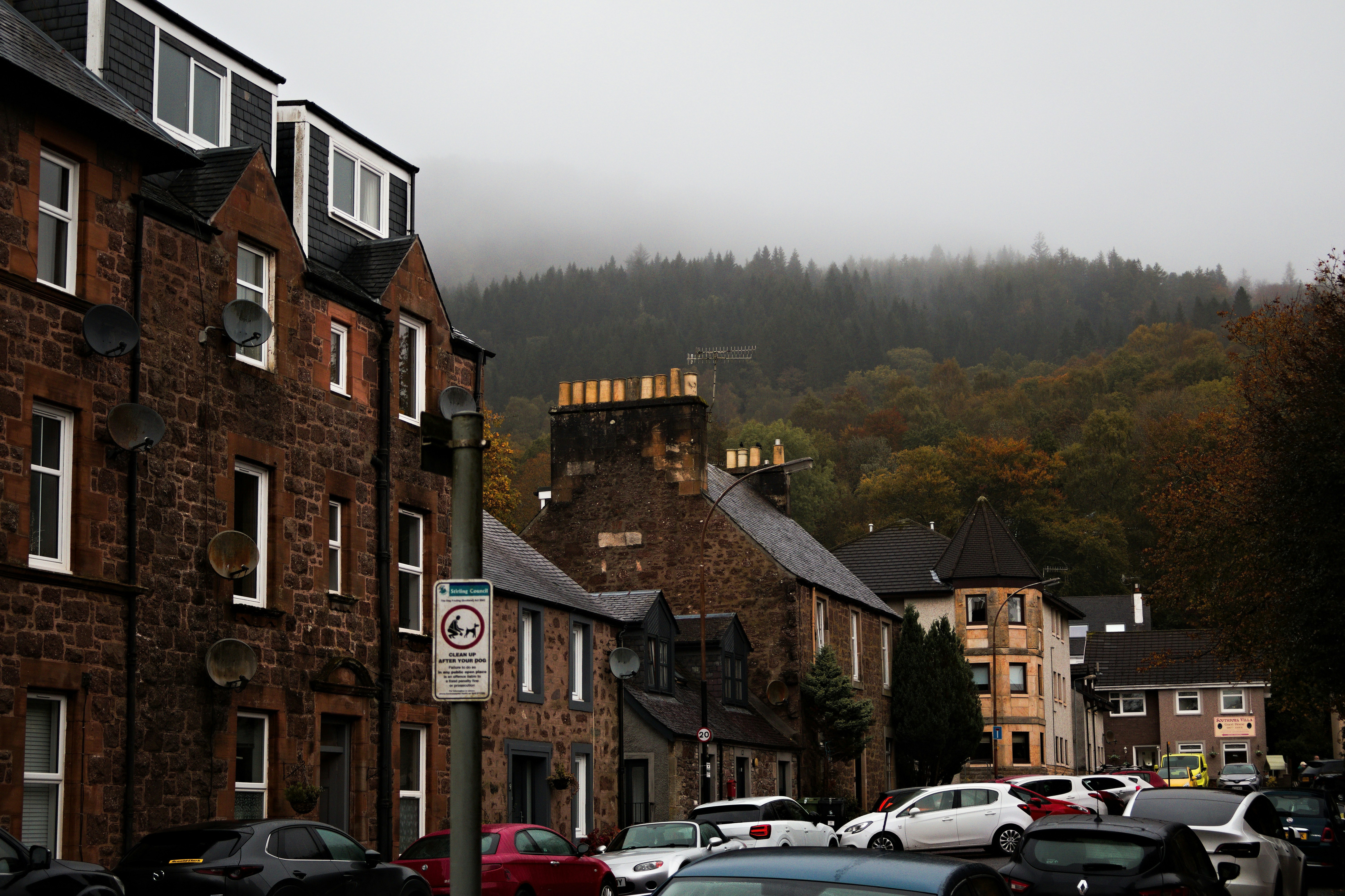 Rainy Highland Row: Brick Terrace Under A Misty Ridge