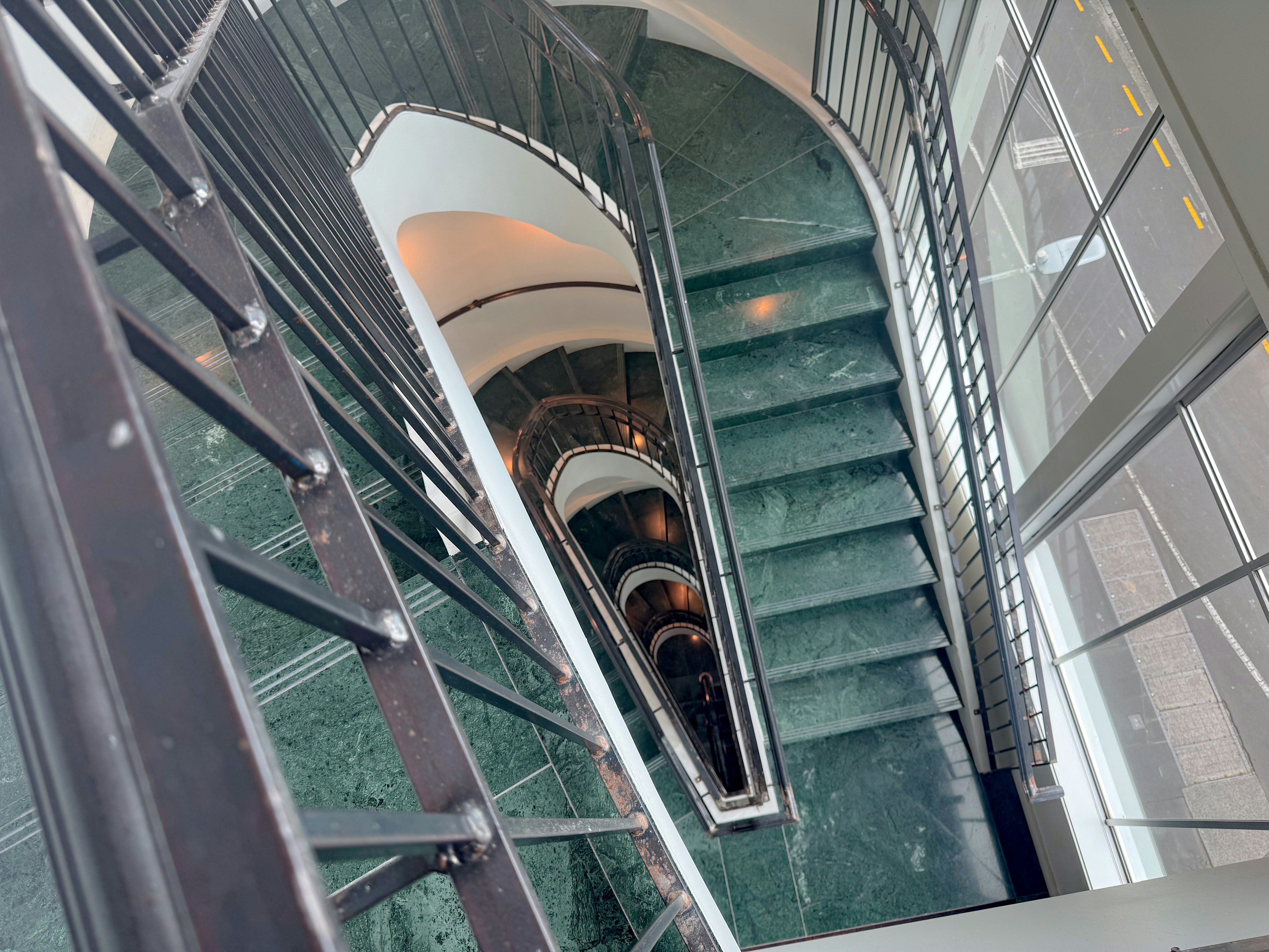 Spiral Staircase: A Glass-encased Descent through Light and Steel