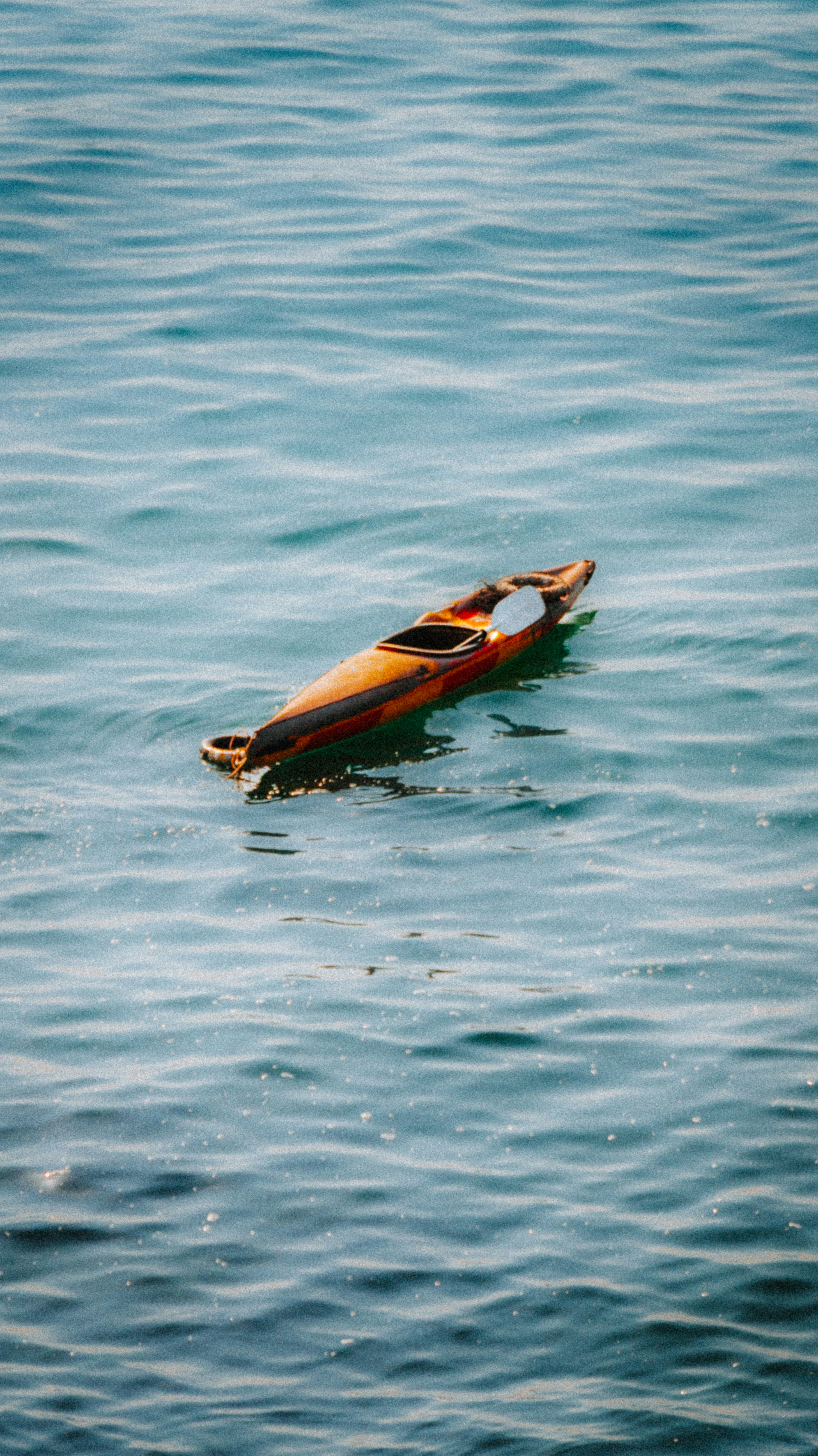 Amber Kayak Adrift on Quiet Blue Currents