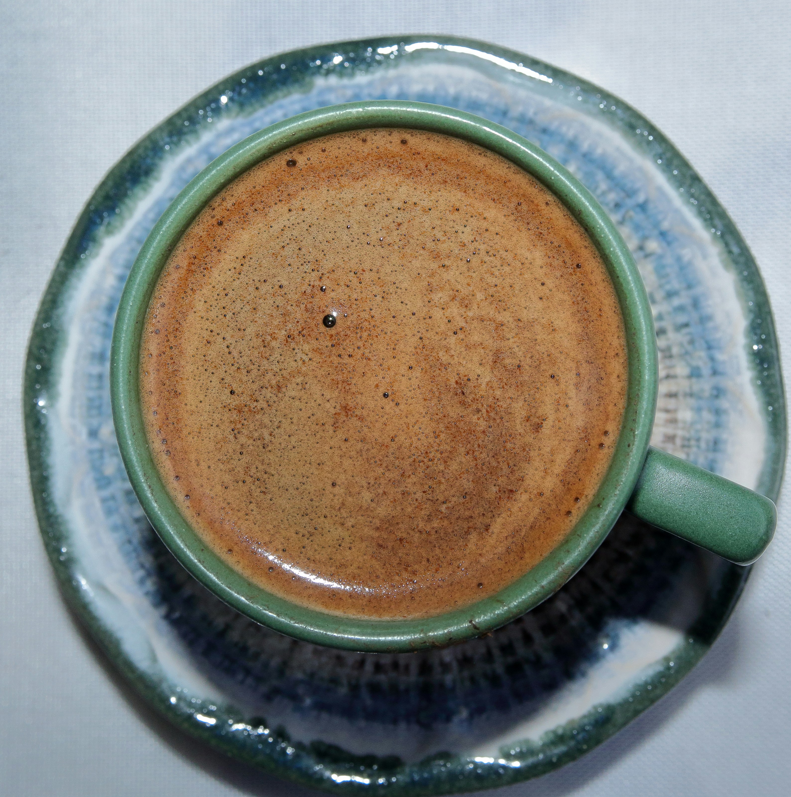 Overhead Espresso: A Ceramic Cup Framing a Quiet Moment