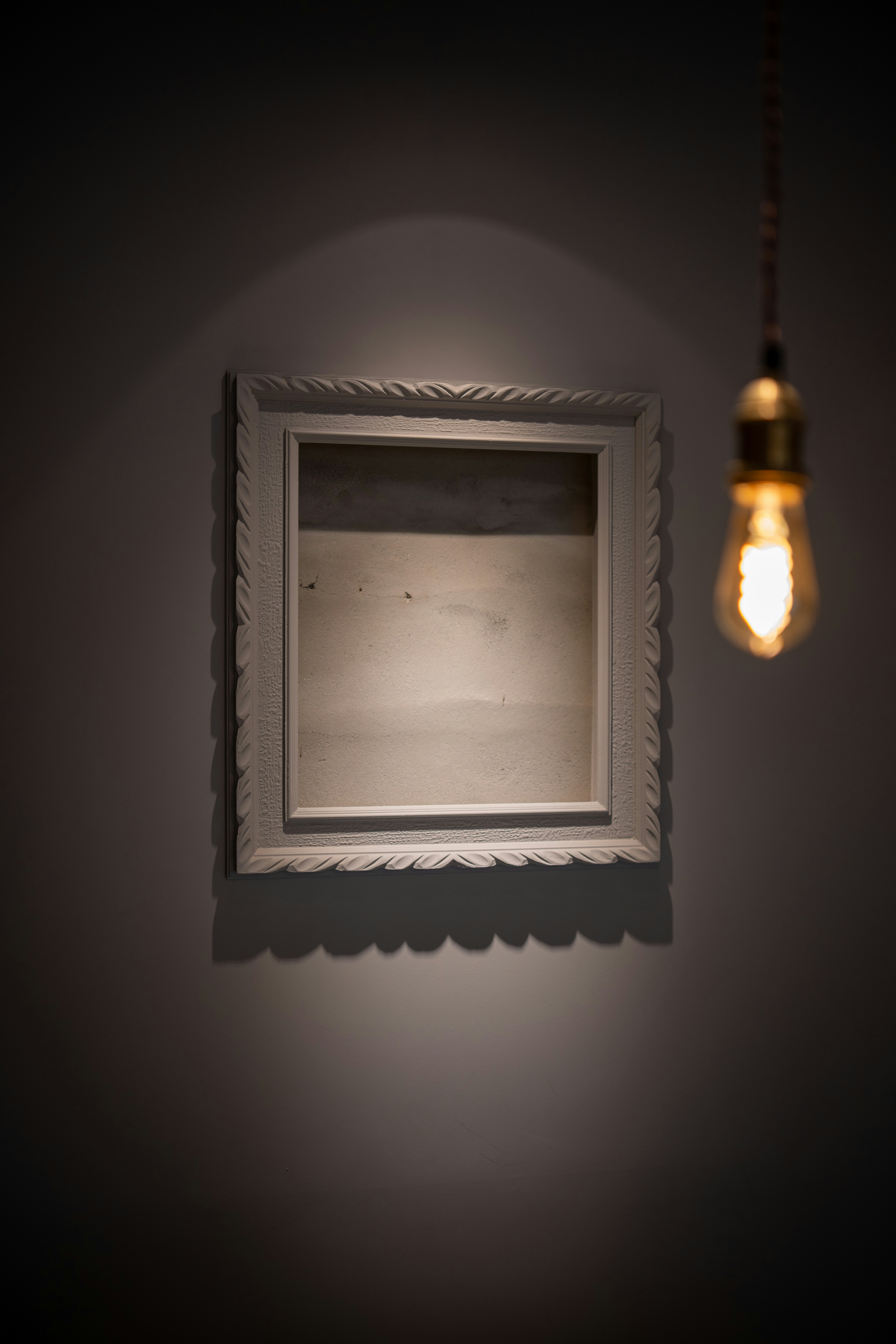 Light Above the Frame: A Framed Mirror and Warm Glow