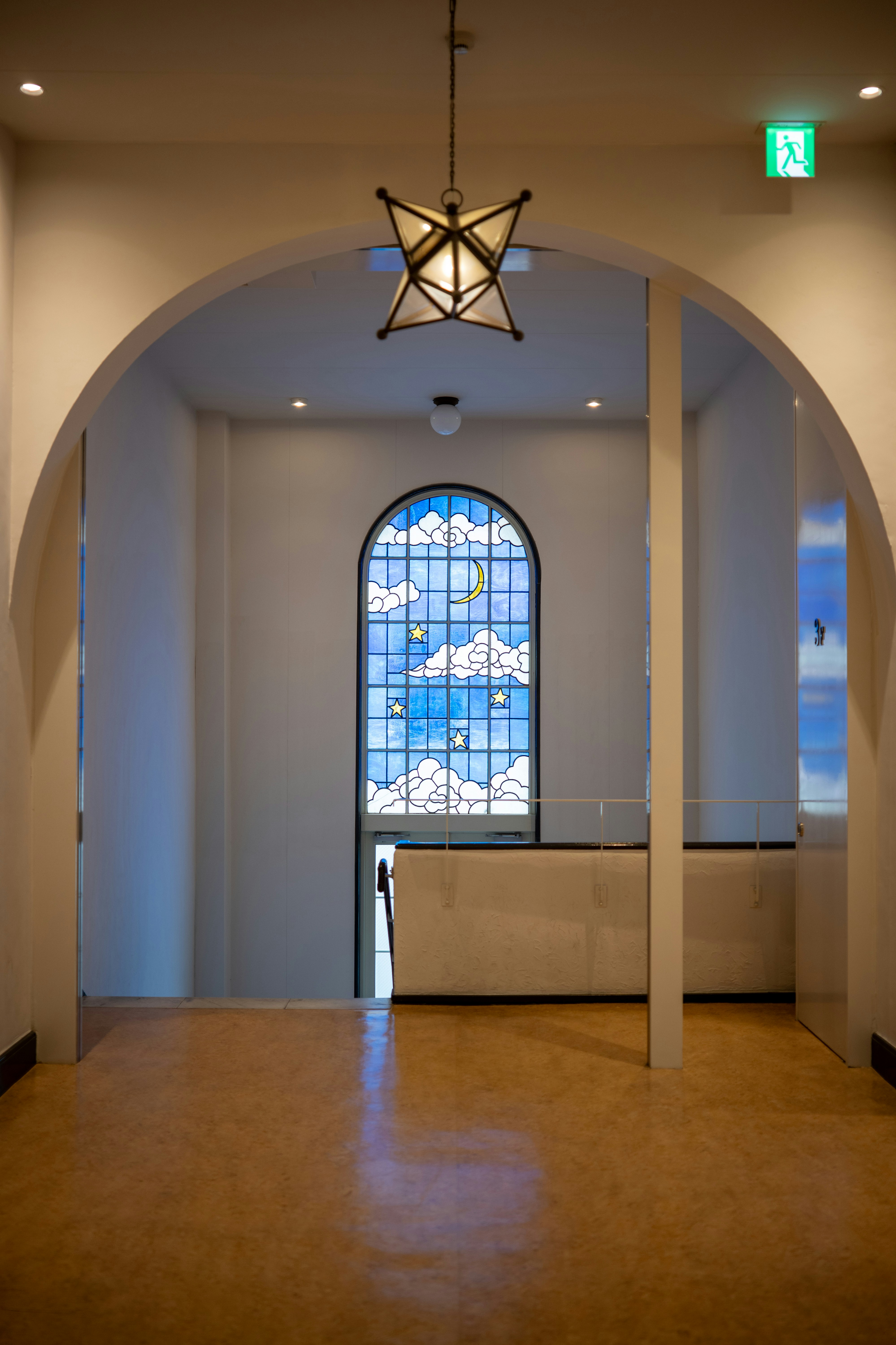 Stained Glass Window Framed by Archway in Quiet Hall