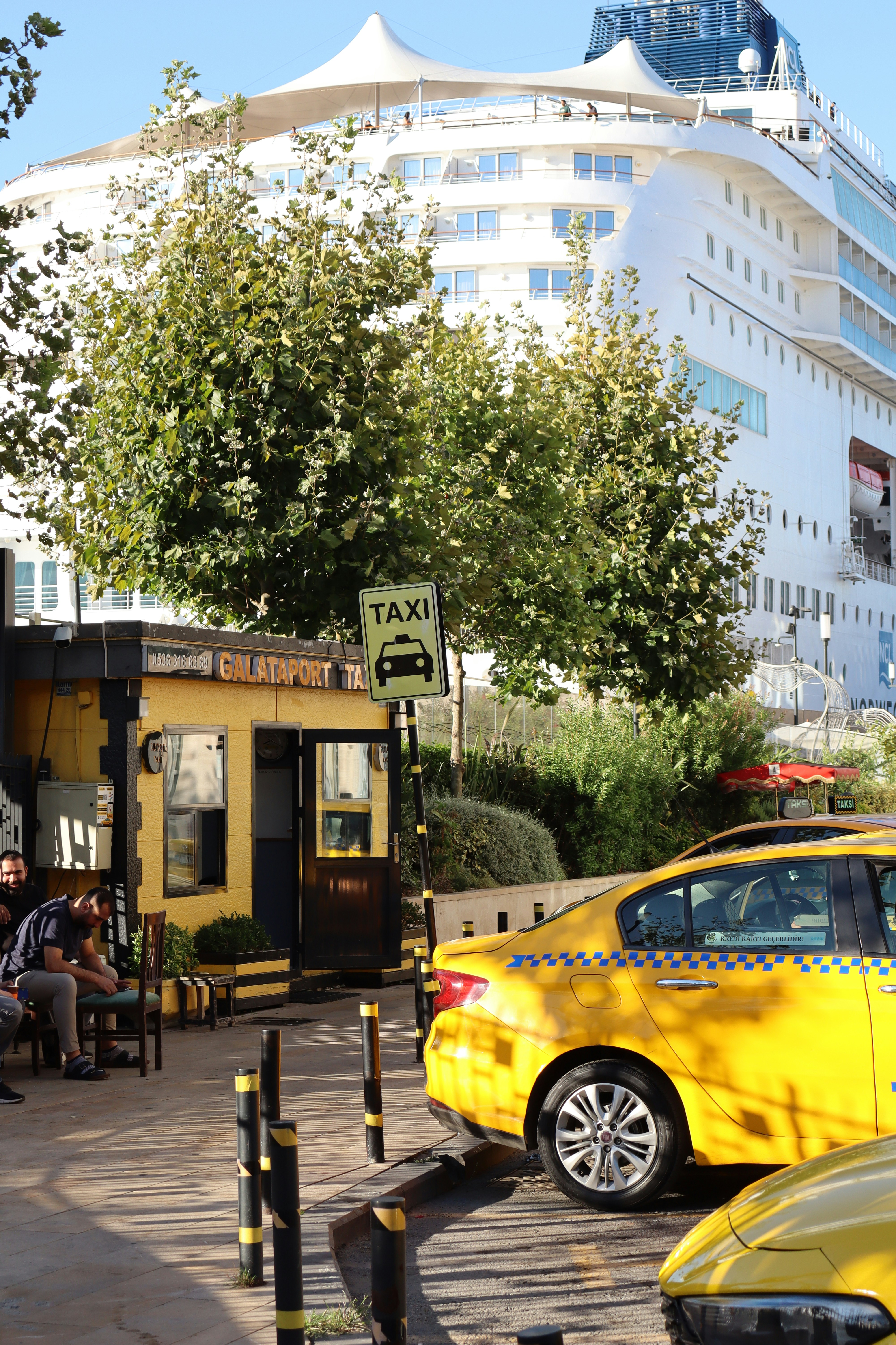 Taxi Stand at the Port: A Sunlit Moment by the Cruise Ship