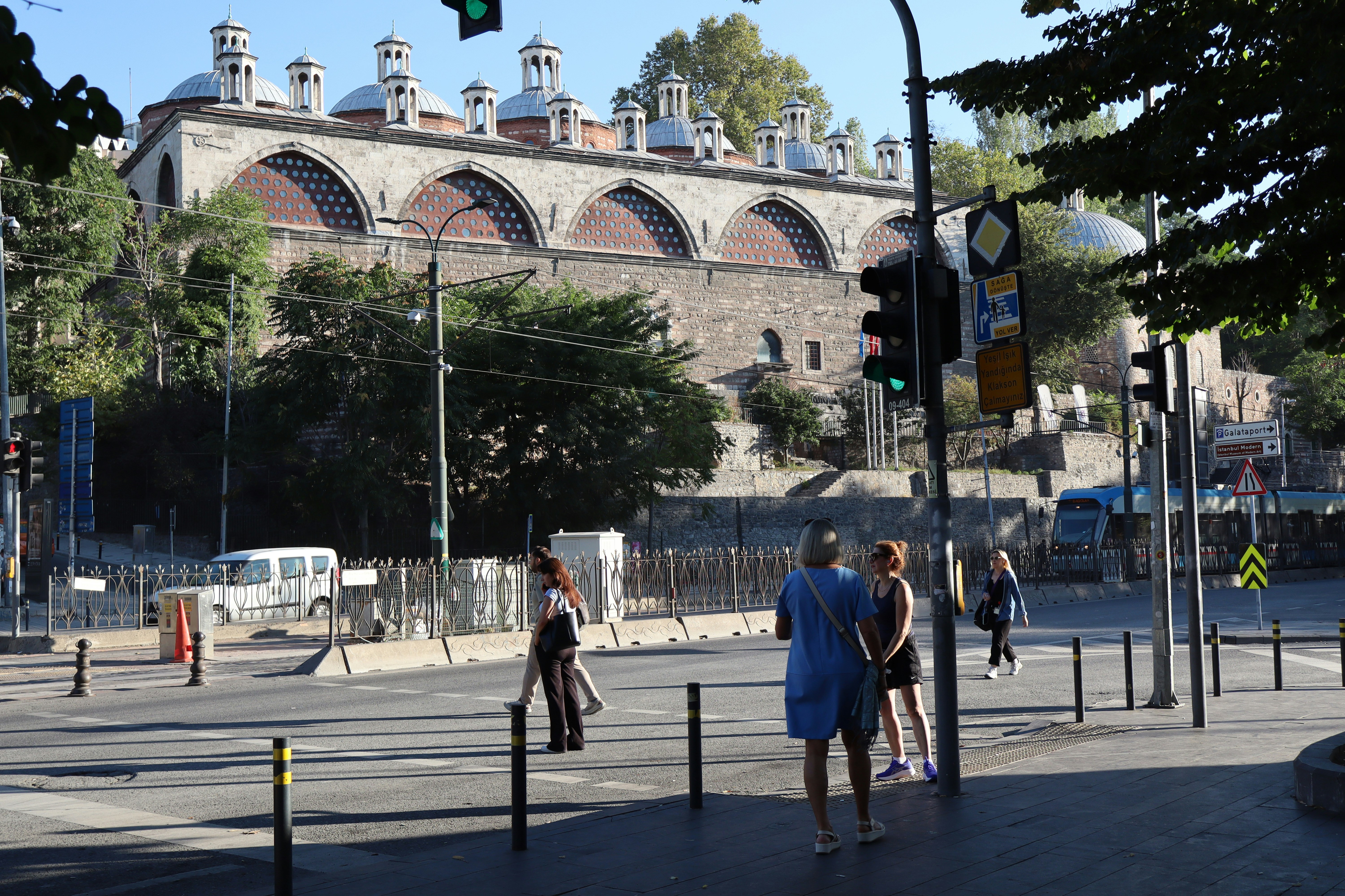 Pedestrian Square with Historic Arched Structure under a Clear Sky