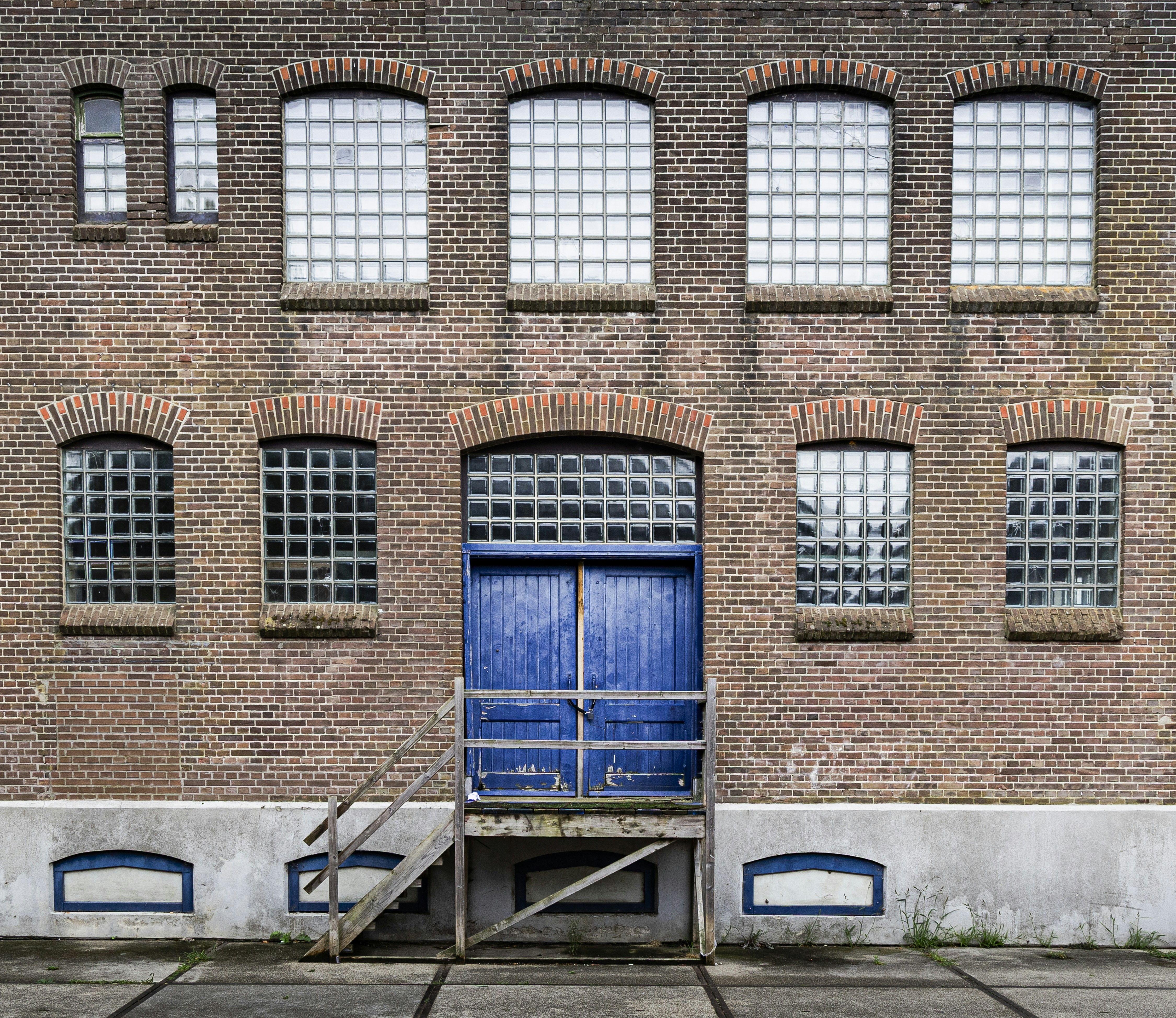 Blue Door in a Brick Facade: An Industrial Quietness