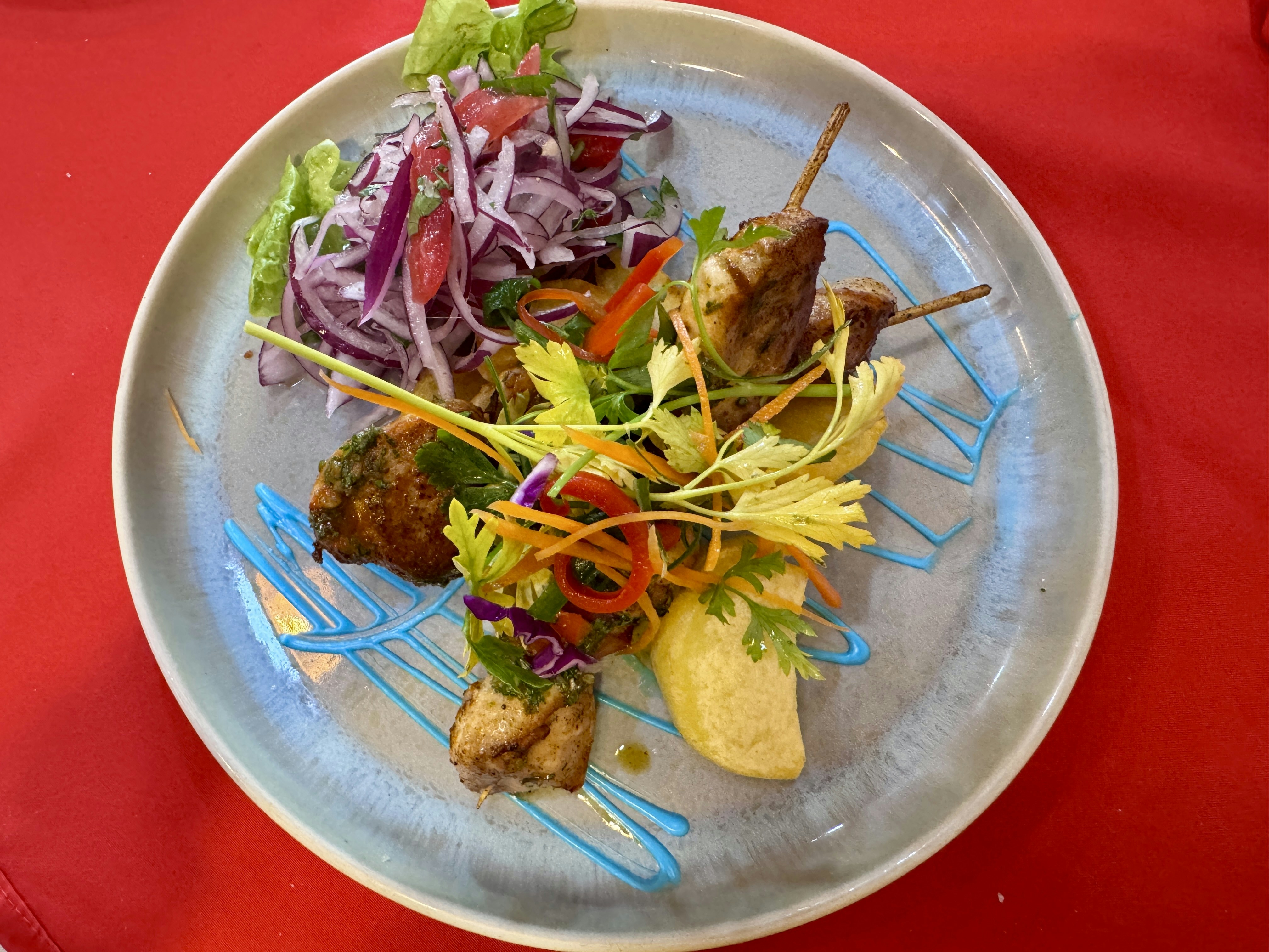 Crisped Skewers and Vibrant Veggie Nest on a Ceramic Plate