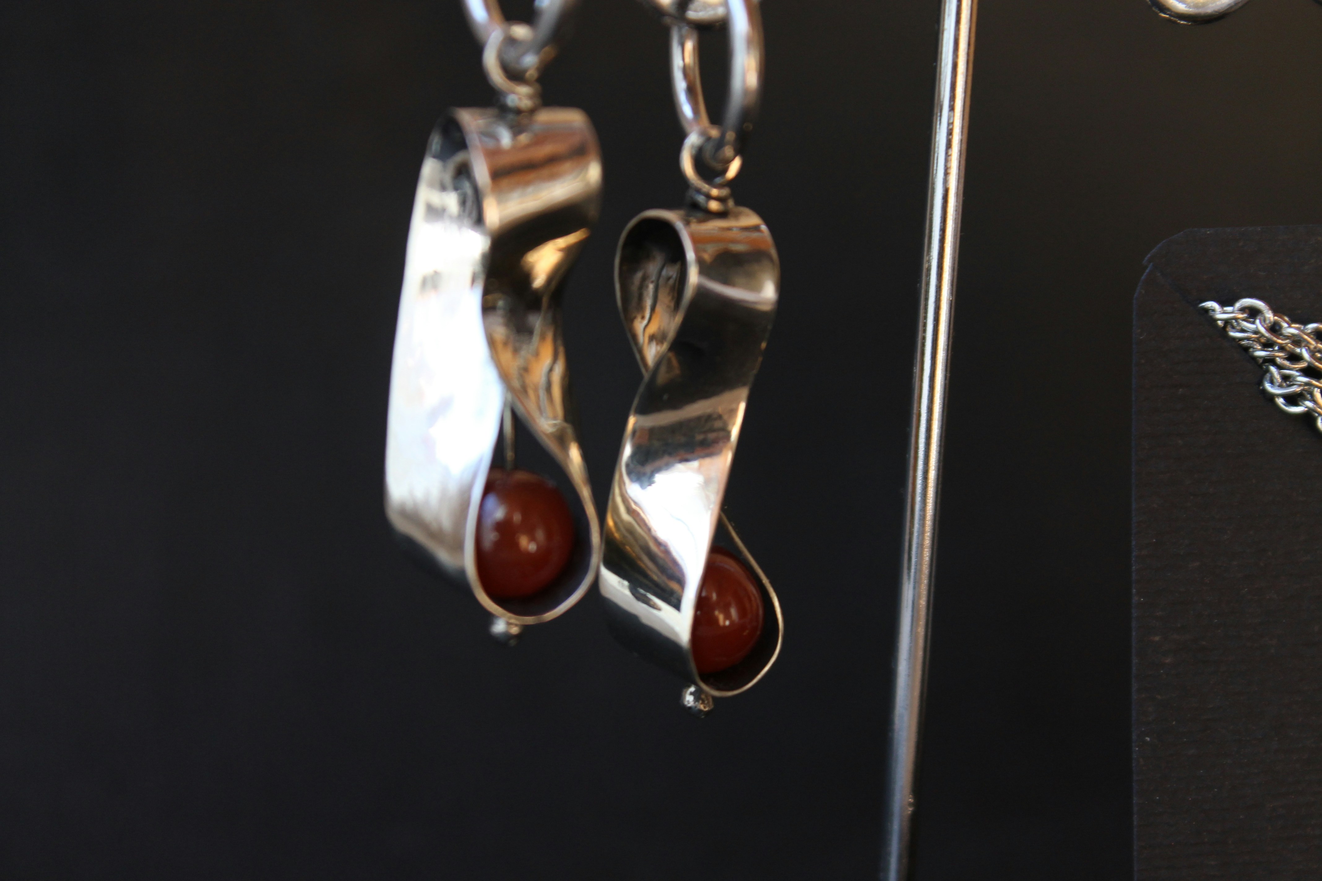 Shimmering Silver Drops and Red Beads on a Dark Backdrop