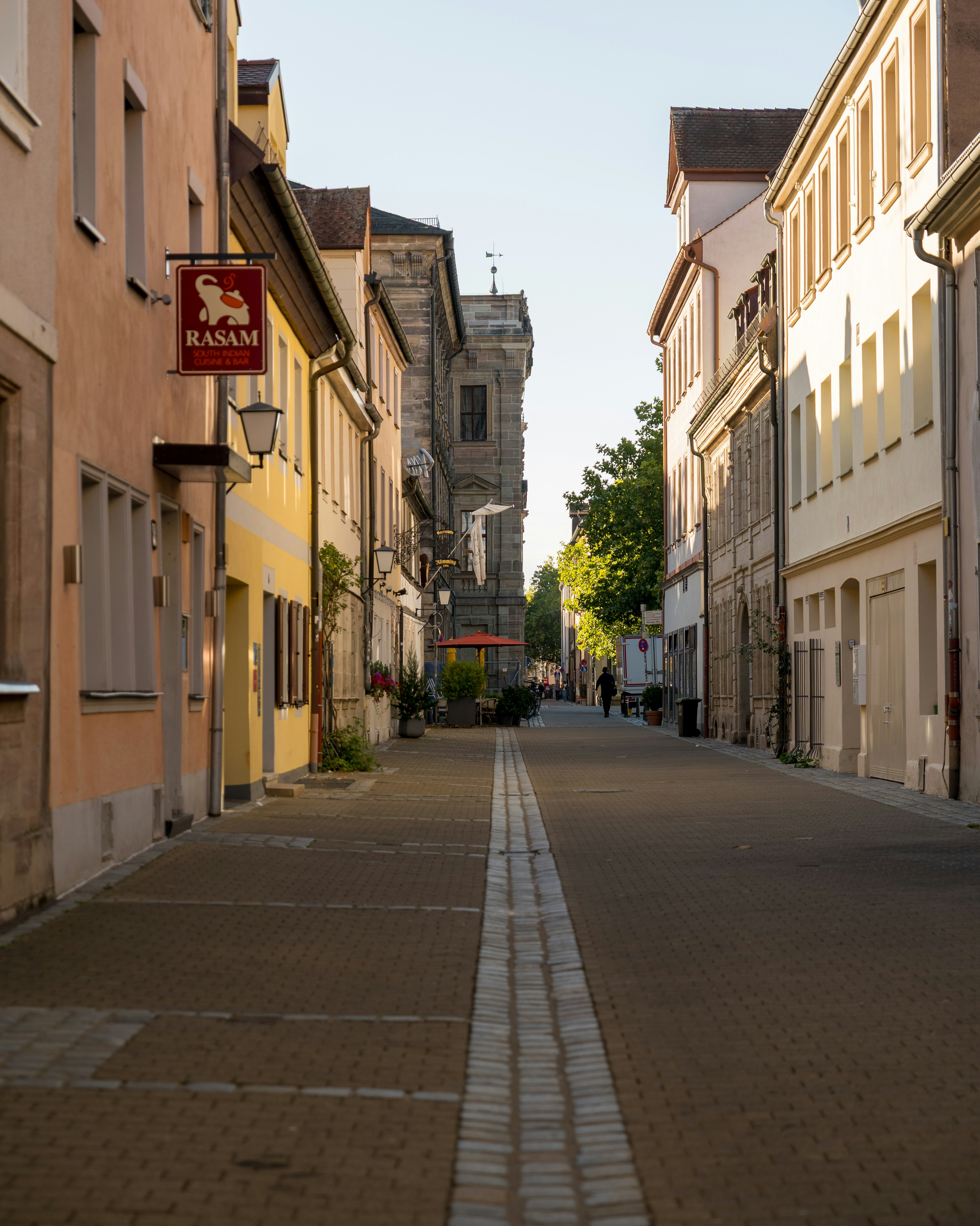 Sunlit European Street Corridor Framed by Colorful Facades