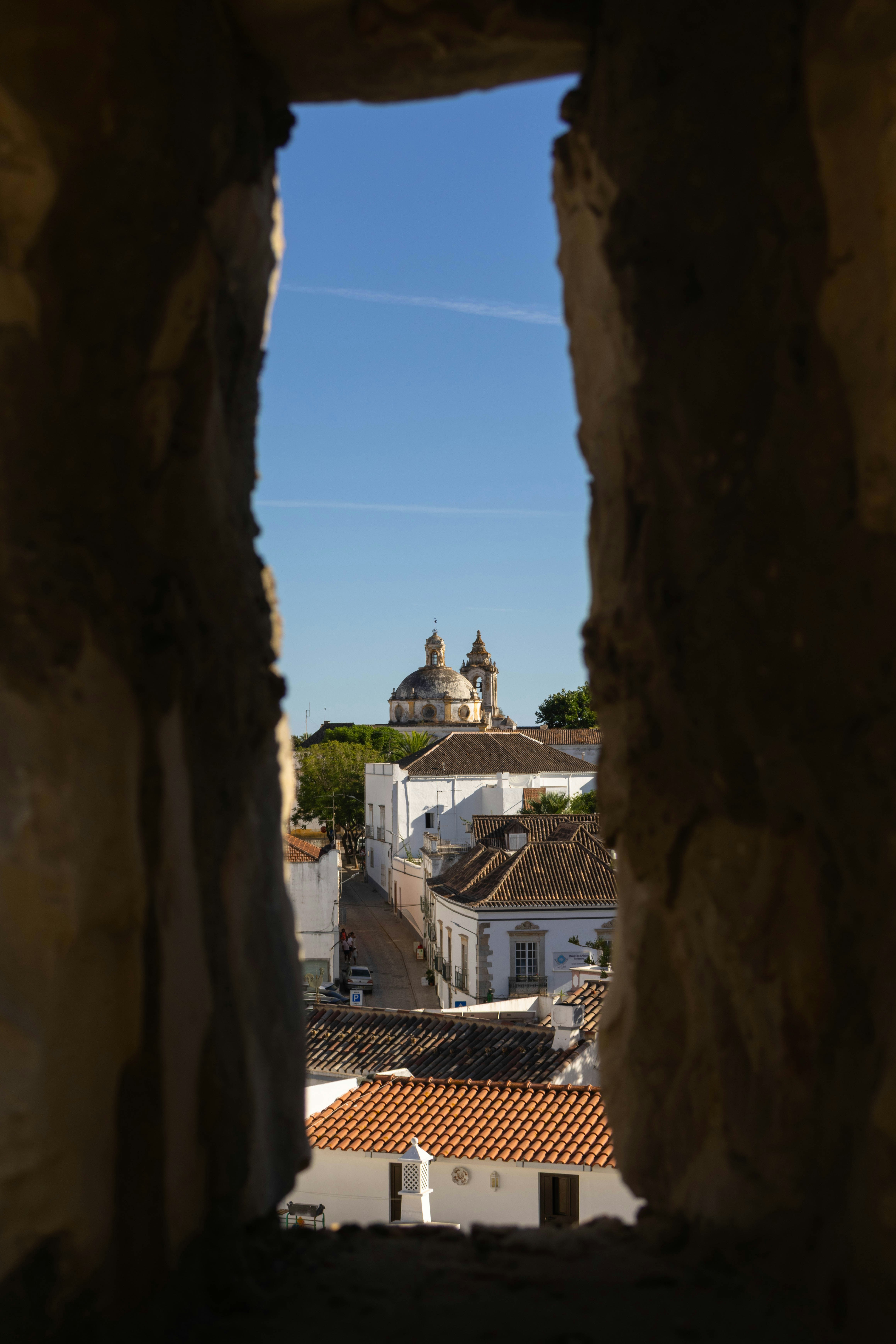 View Through a Narrow Window: A Historic Town Unfolds Beneath a Blue Sky